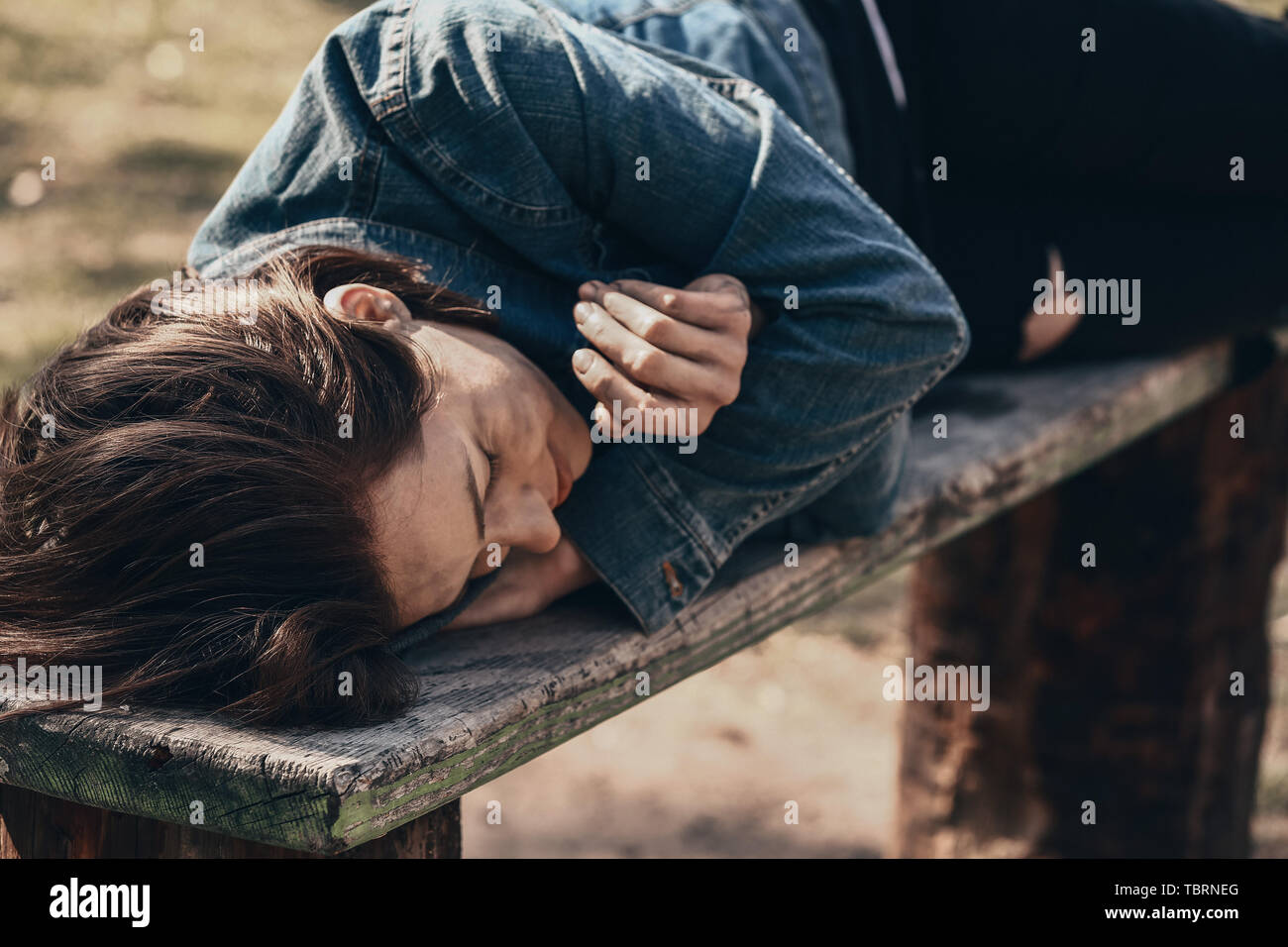 Poor homeless woman lying on bench outdoors Stock Photo - Alamy