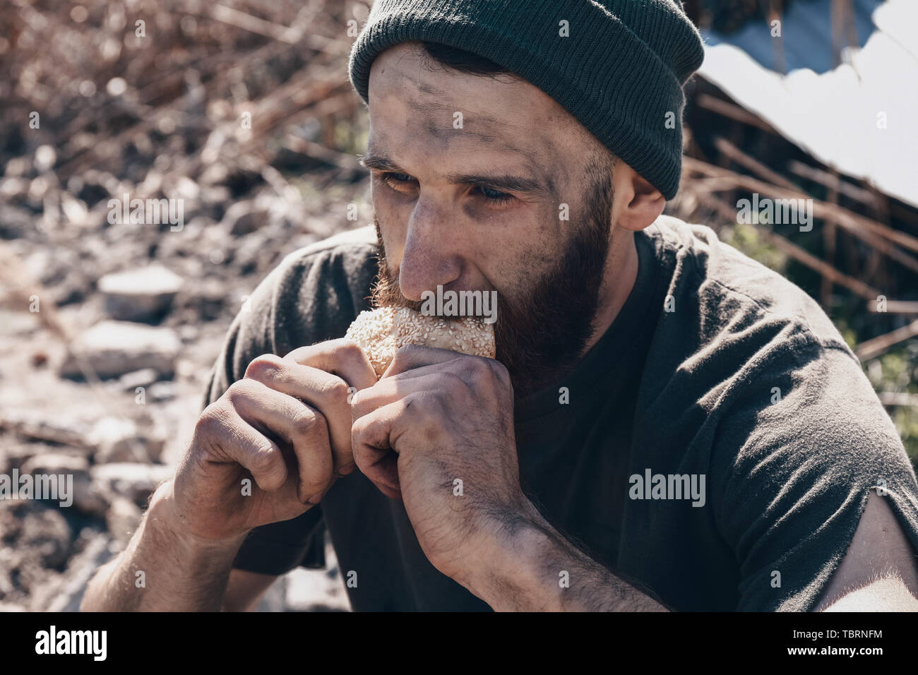 Poor homeless man eating bread outdoors Stock Photo - Alamy