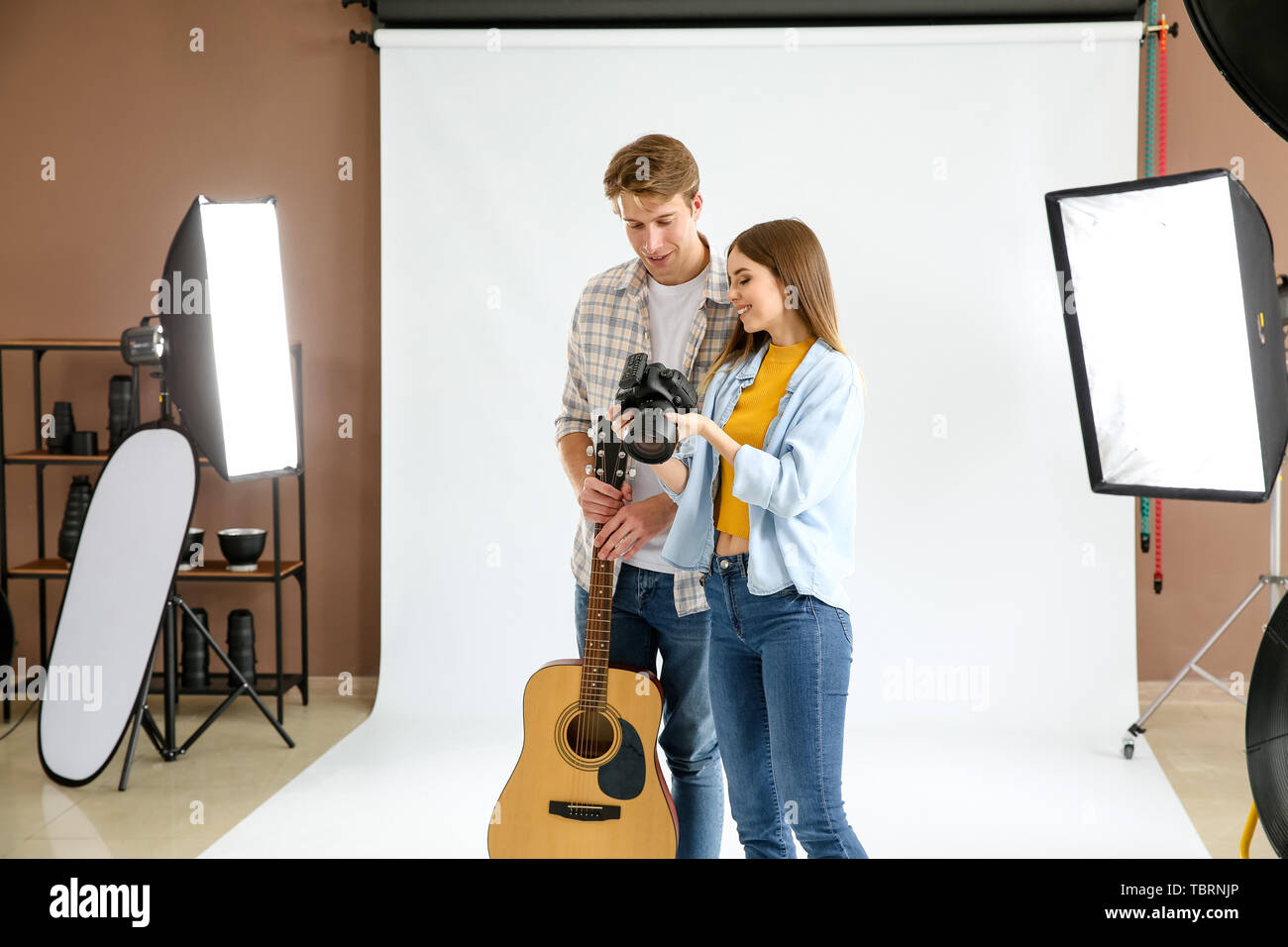 Professional photographer showing pictures to model in studio Stock ...