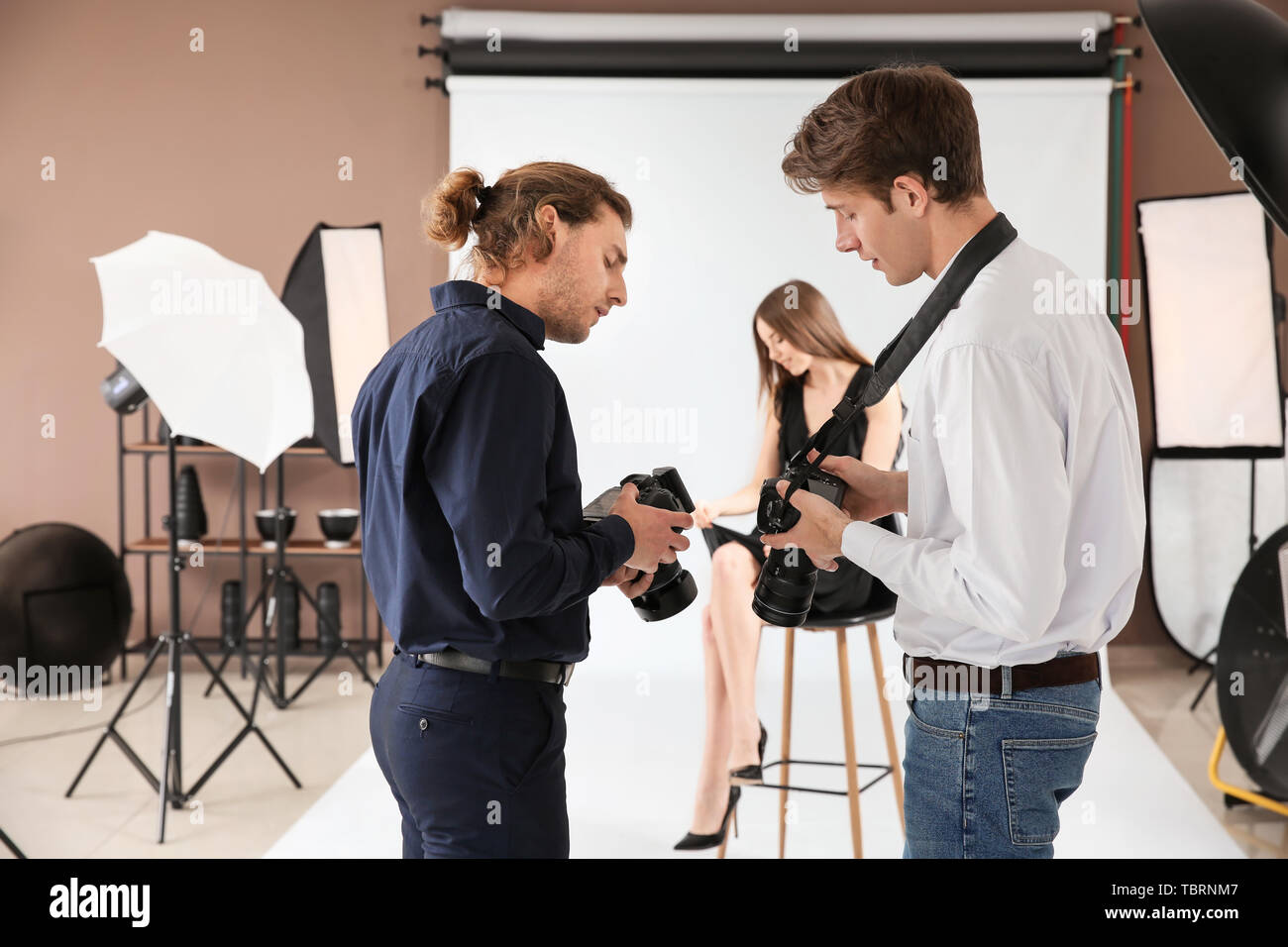 Professional photographers discussing pictures in studio Stock Photo ...