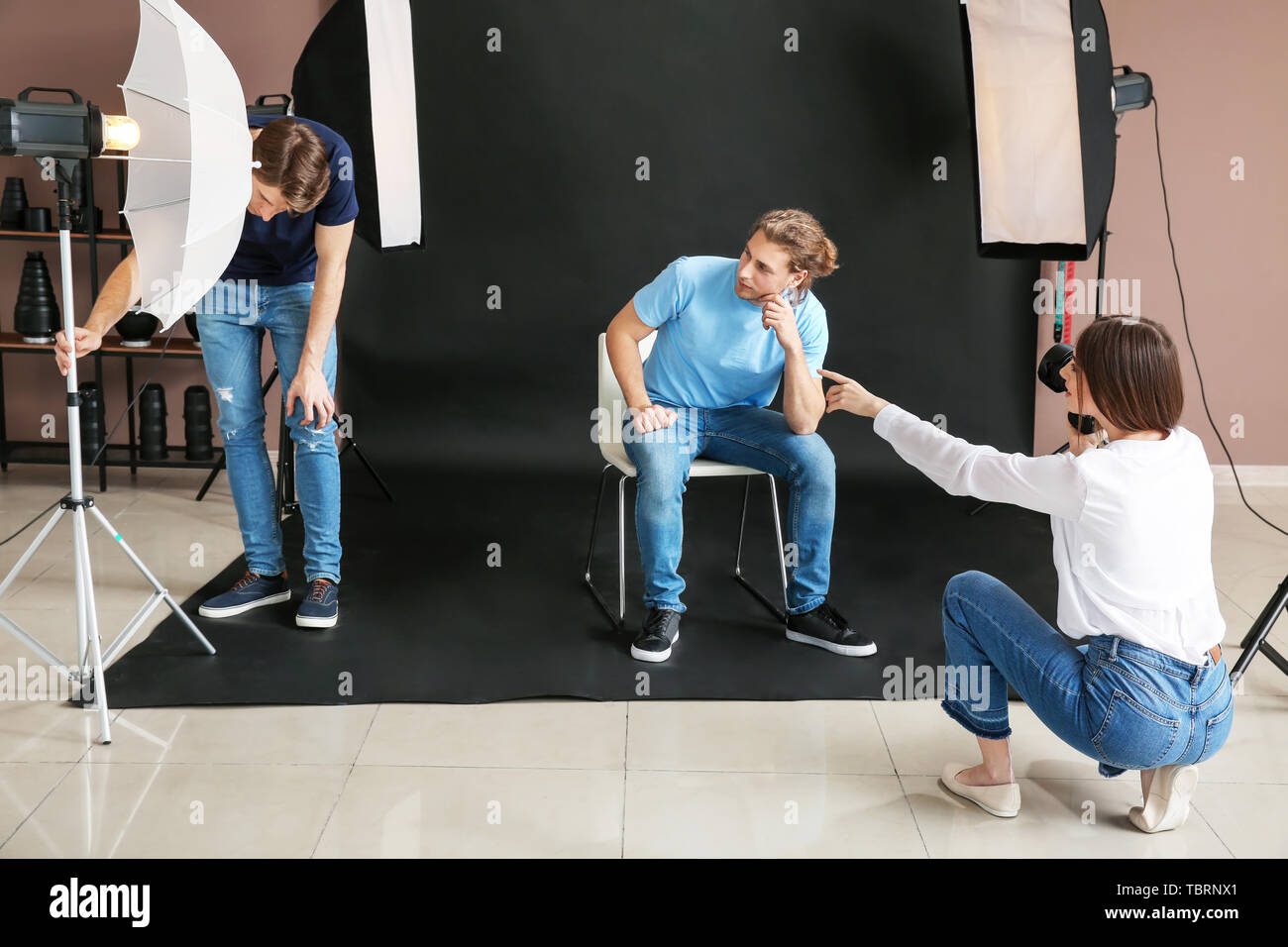 Professional photographer working with model in studio Stock Photo - Alamy