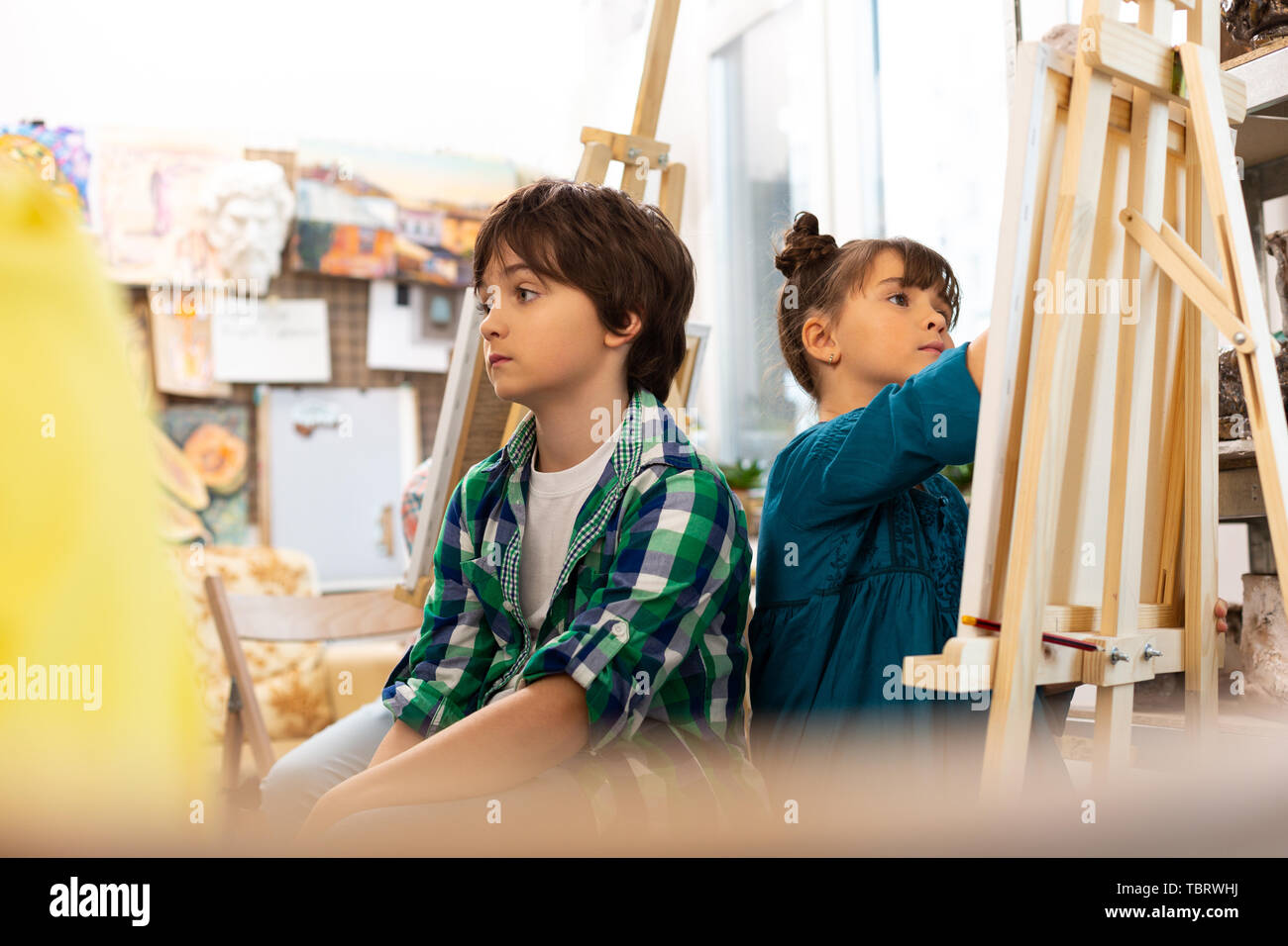 Boy feeling bored. Dark-haired boy feeling bored during art lesson at ...