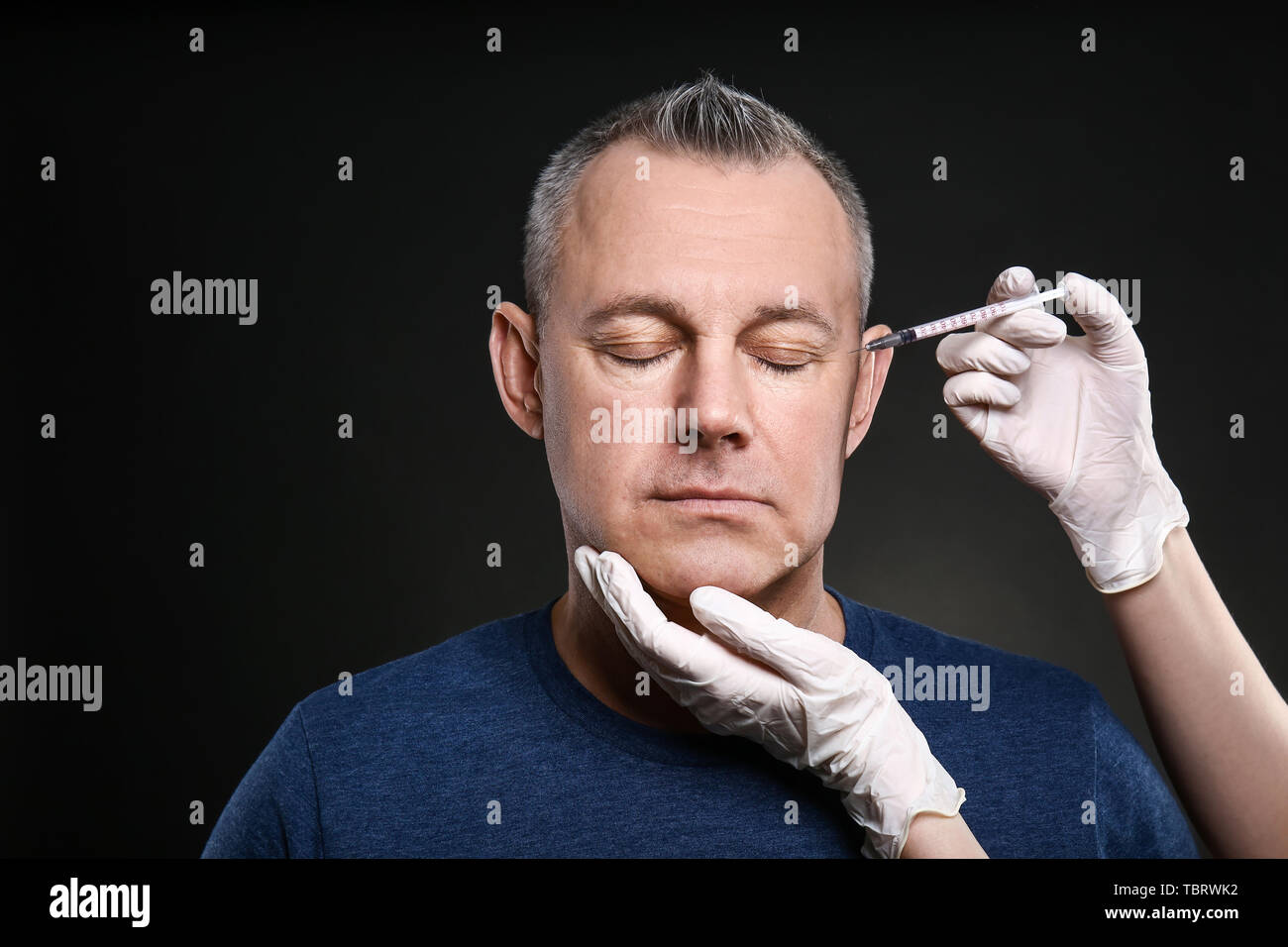 Middle-aged man and hands holding syringe for anti-aging injections on ...