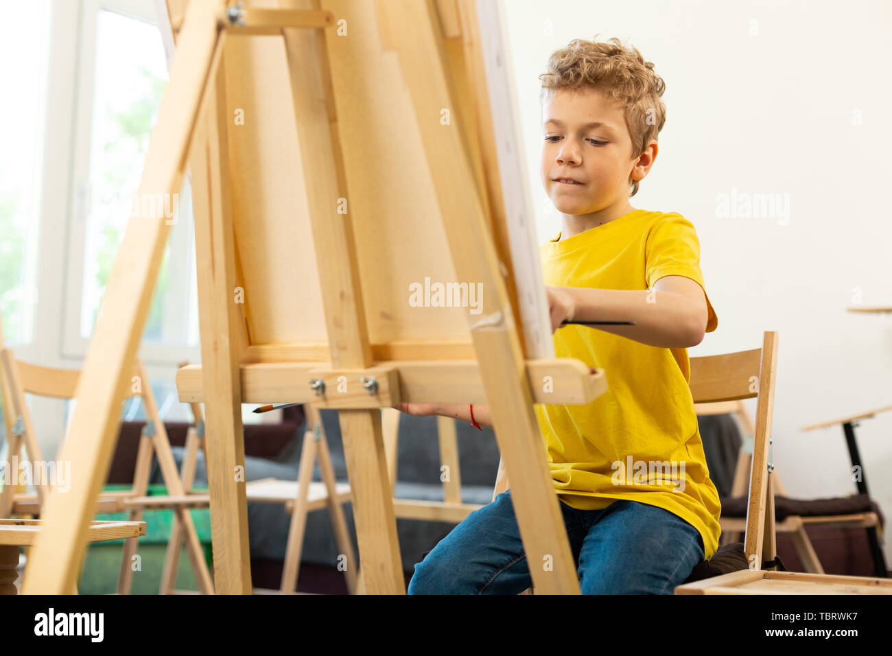 Boy feeling good. Talented boy feeling good and busy while painting in ...
