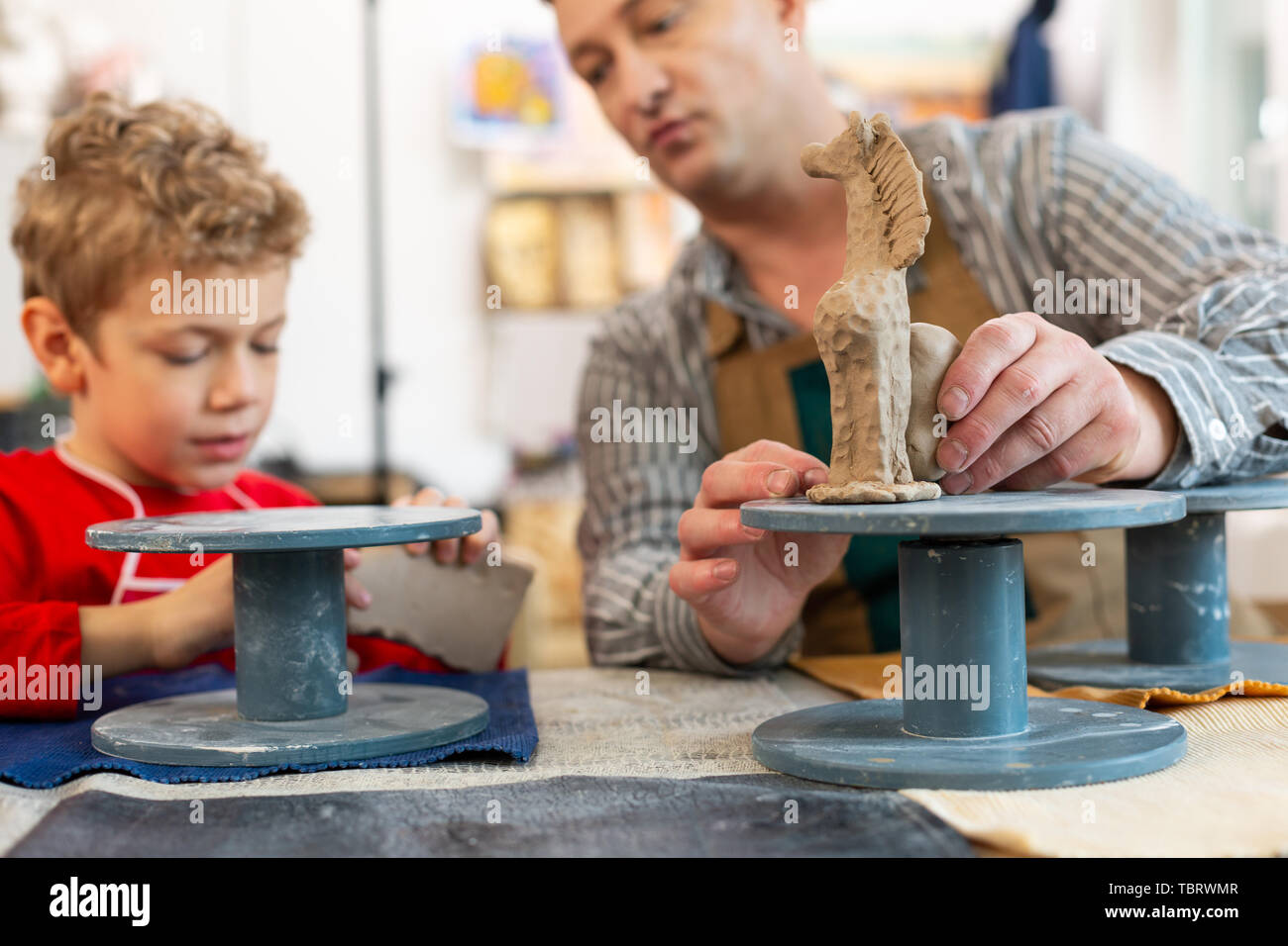 Sculpting clay figures. Close up of teacher and student sculpting clay ...