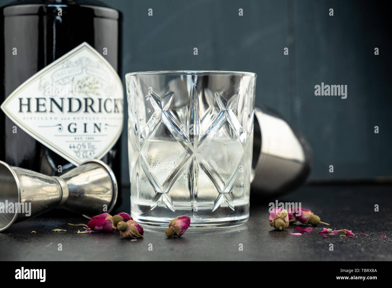 70 cl bottle Hendricks distilled gin with glass and ice on dark rustic ...
