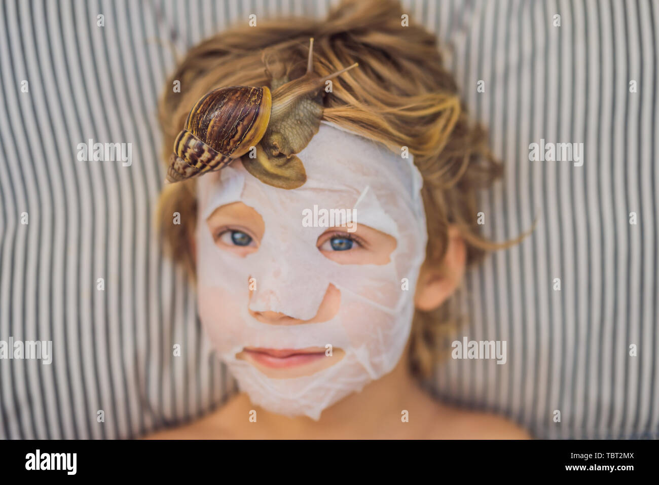 Strongly younger from the mask with snail mucus. A child in a mask for ...