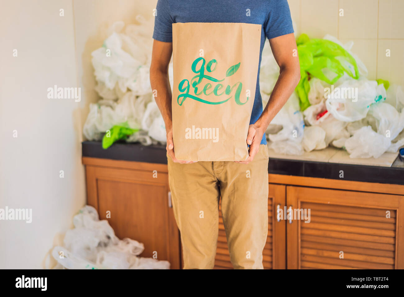 Man holding a package with the inscription GO GREEN amid a pile of ...