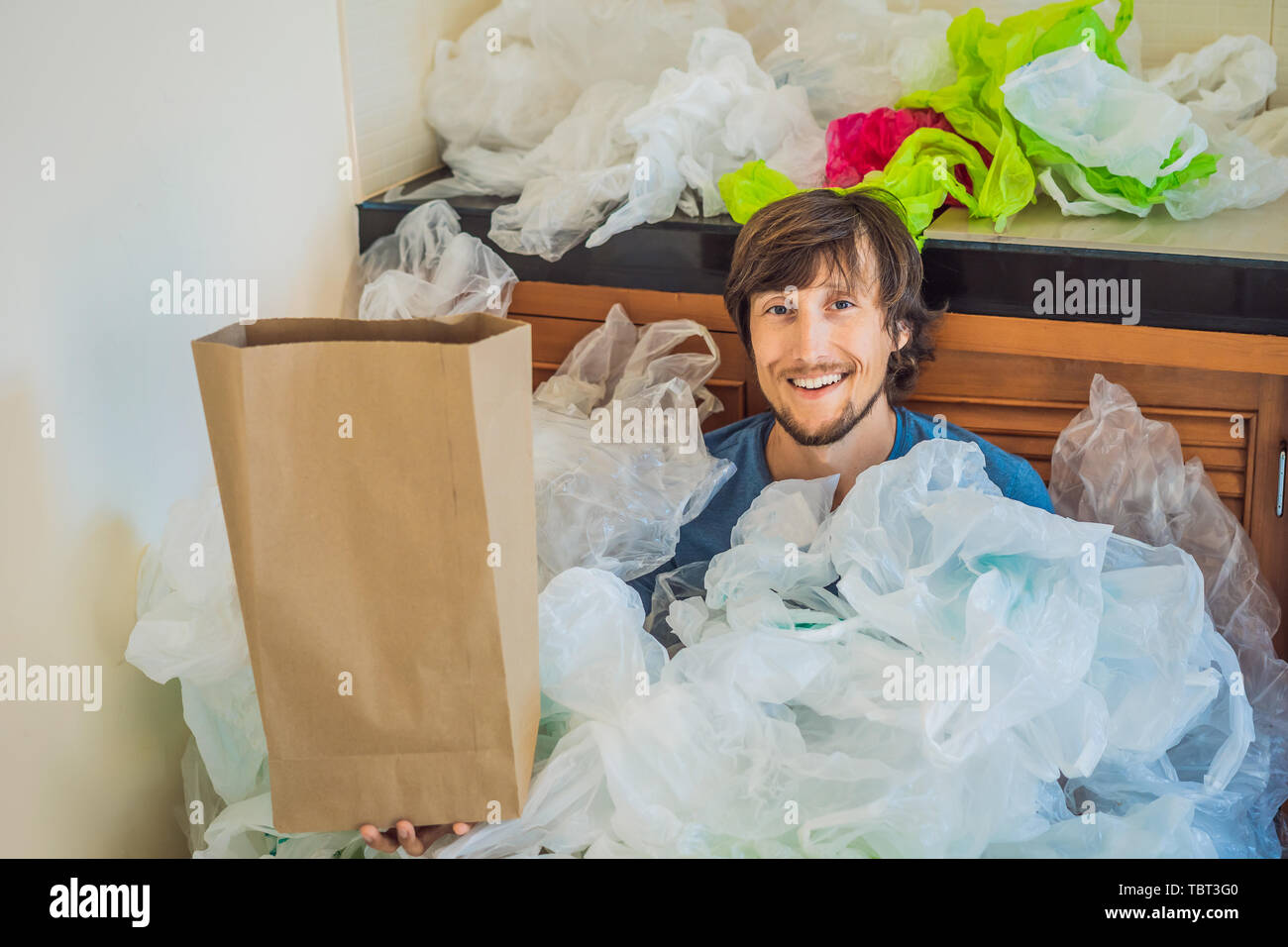 Man holding paper bag amid a pile of plastic bags. Zero waste concept ...