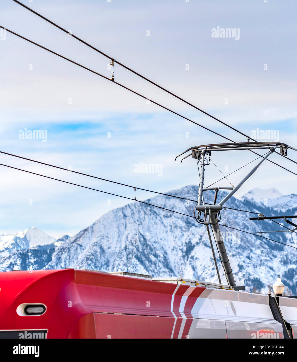 Square Shiny exterior of a red and white train connected to thick cable ...