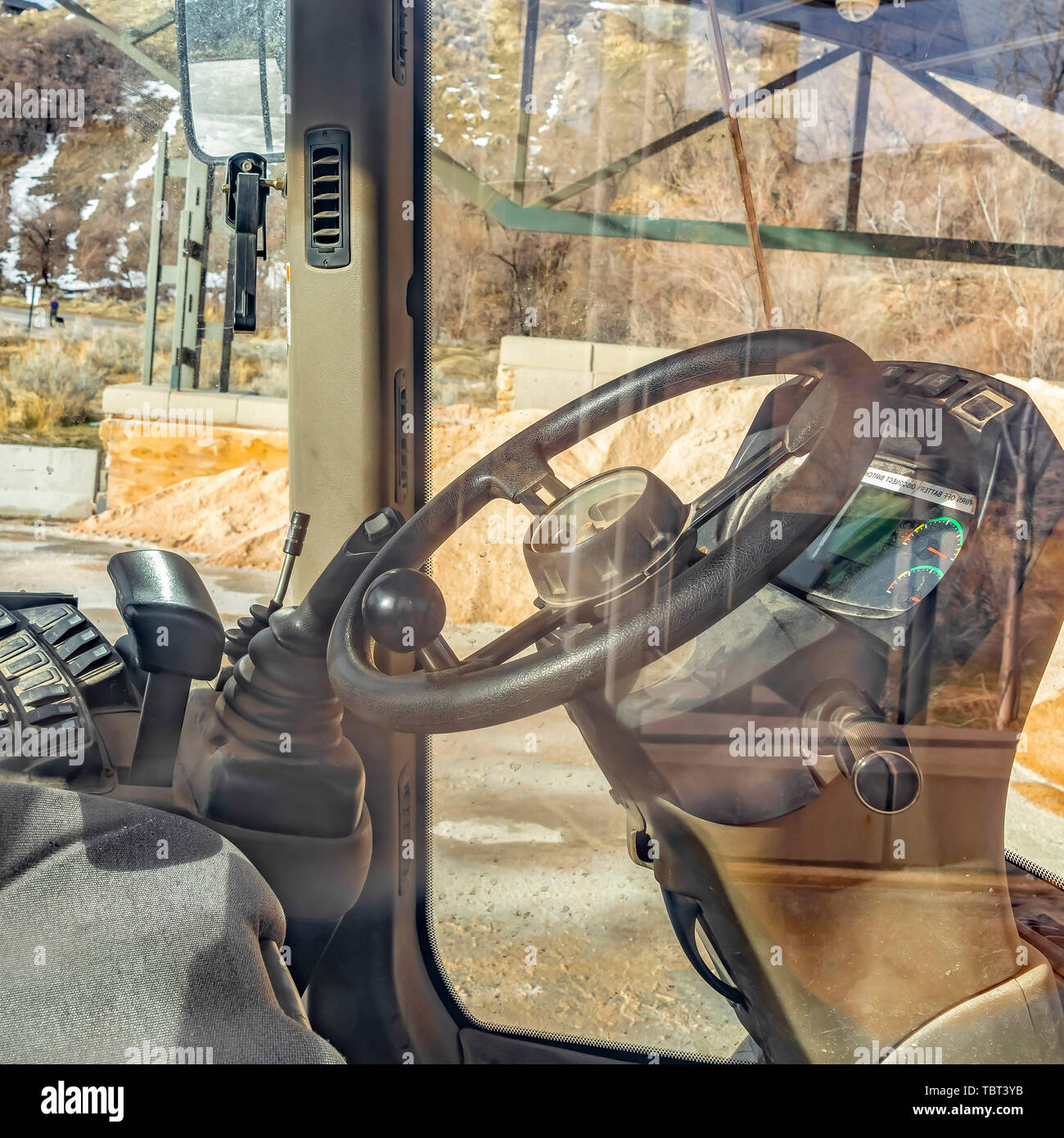 Square frame Construction vehicle cab interior with hill and sky in the ...