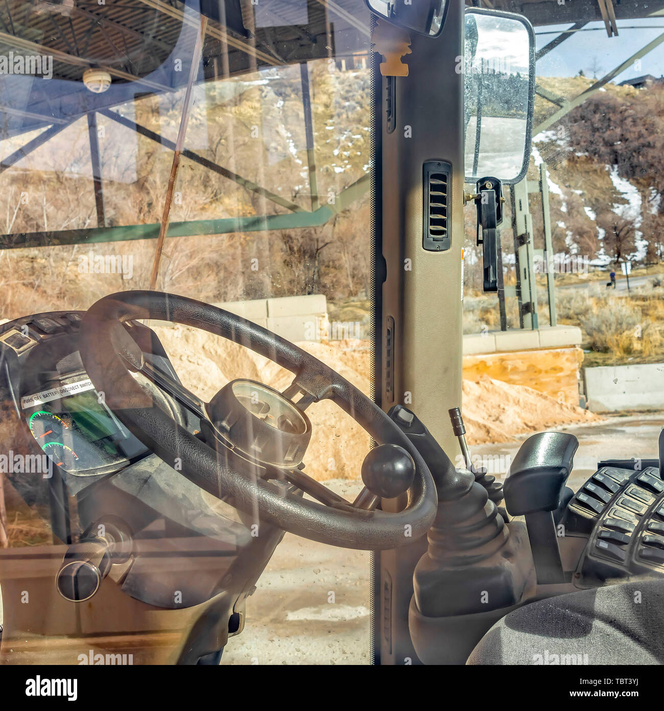 Square Construction vehicle cab interior with hill and sky in the sunny ...