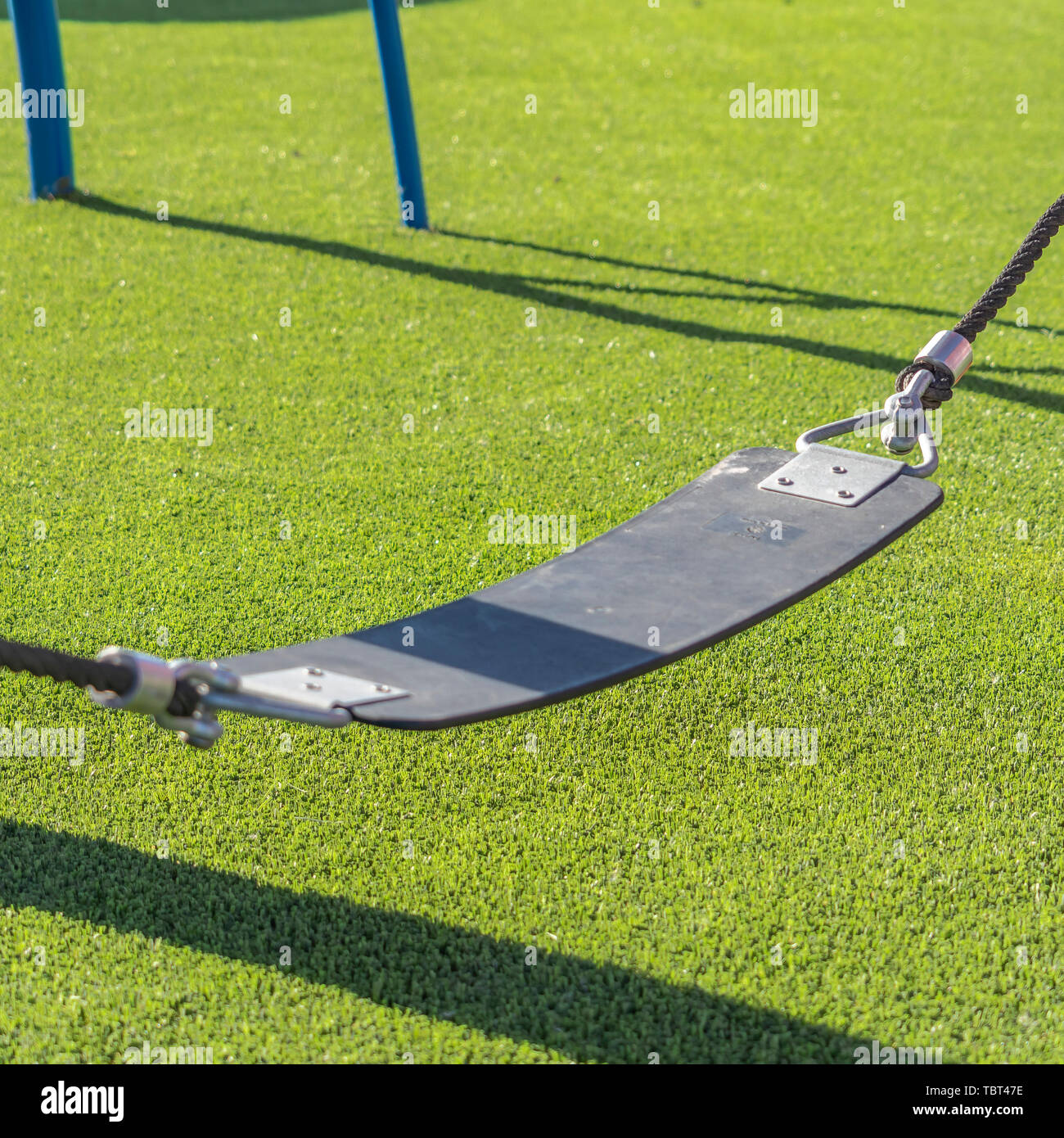 Square Play area with a seat supported by ropes that are connected to ...