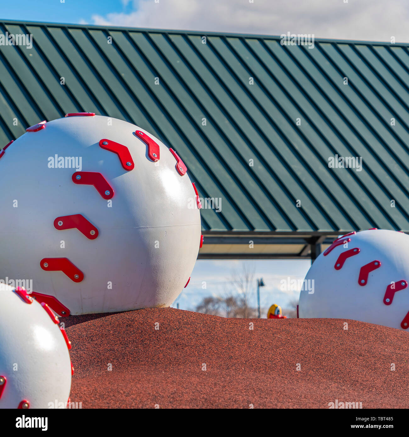 Square Huge baseball decoration on top of a brown mound at a playground ...