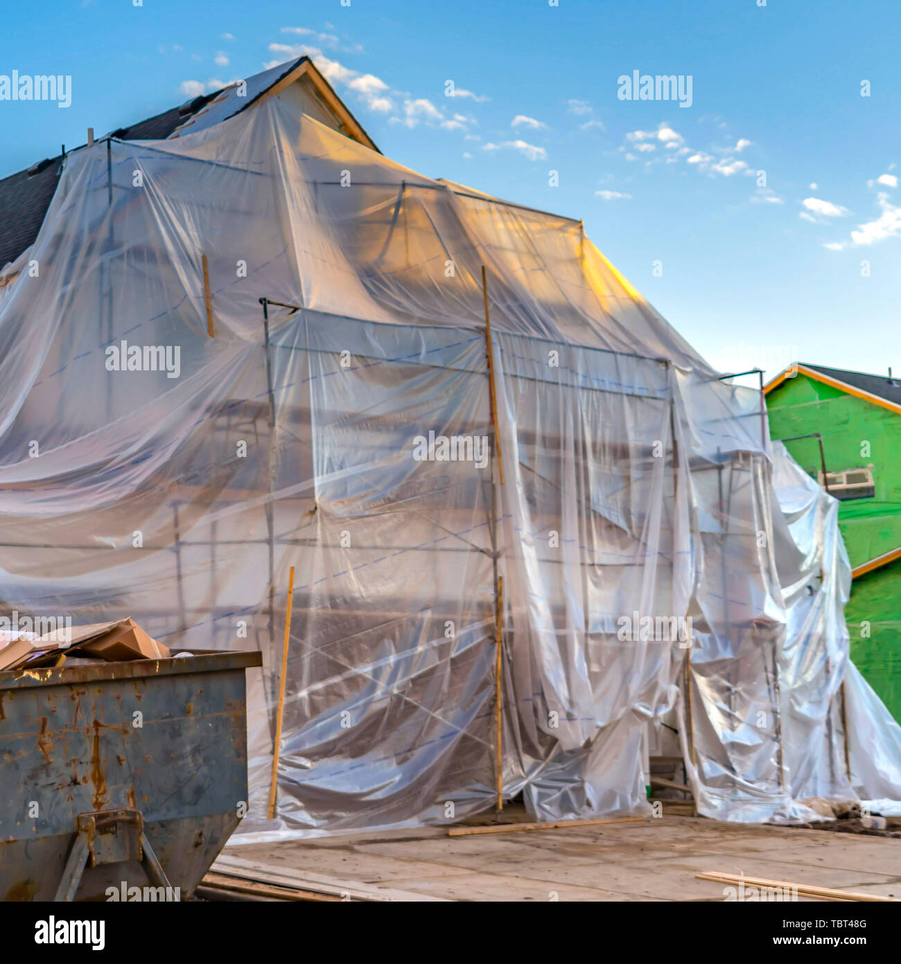Square Plastic sheet covering an unfinished house and scaffoldings ...