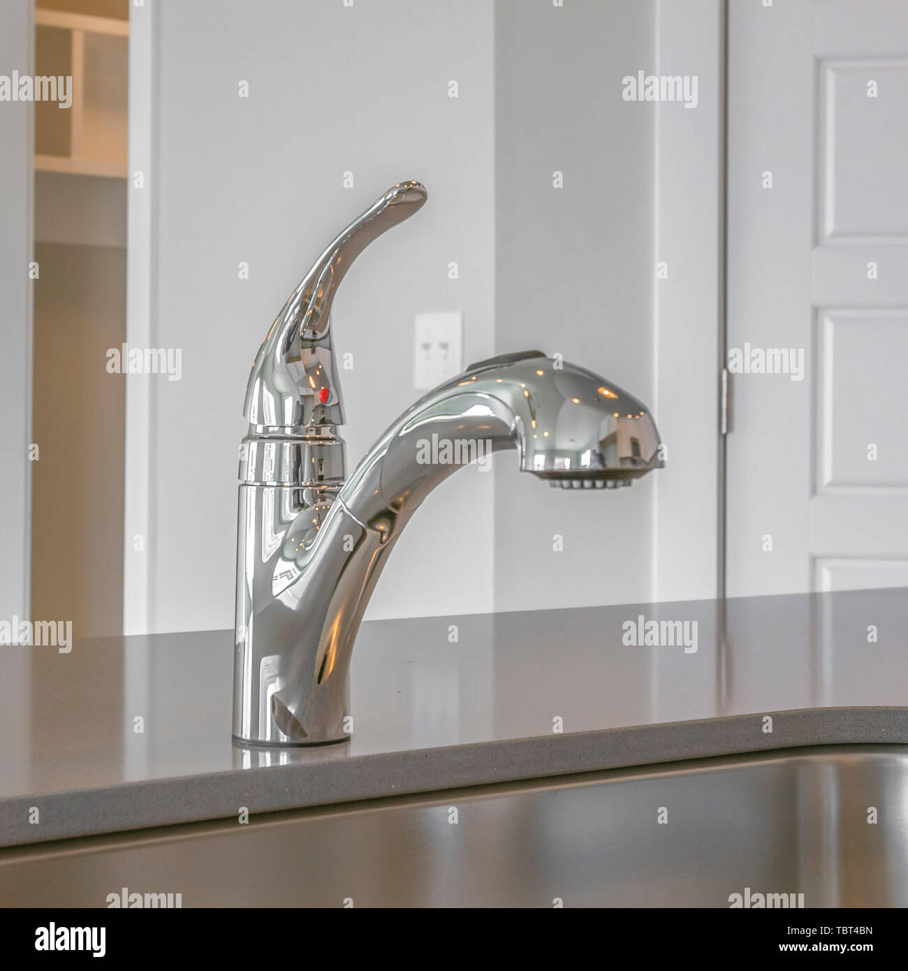 Square Close up of the shiny sink and faucet inside the kitchen of a ...