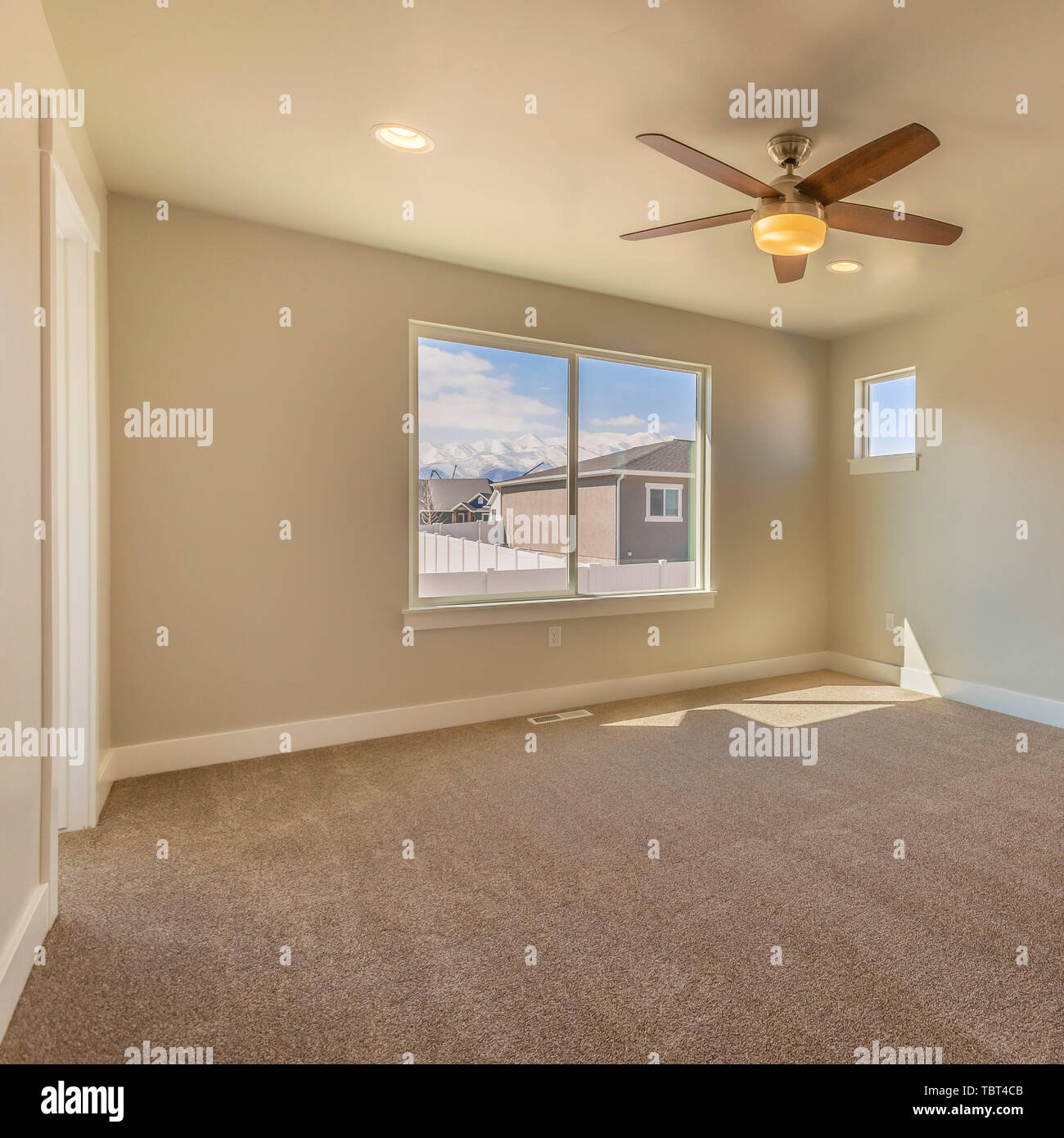 Square Empty room of a new house with beige wall paint and carpeted ...