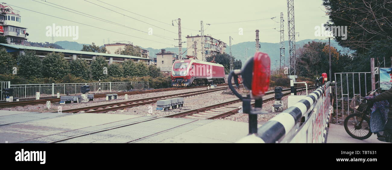 An electrified train passing through the intersection Stock Photo - Alamy