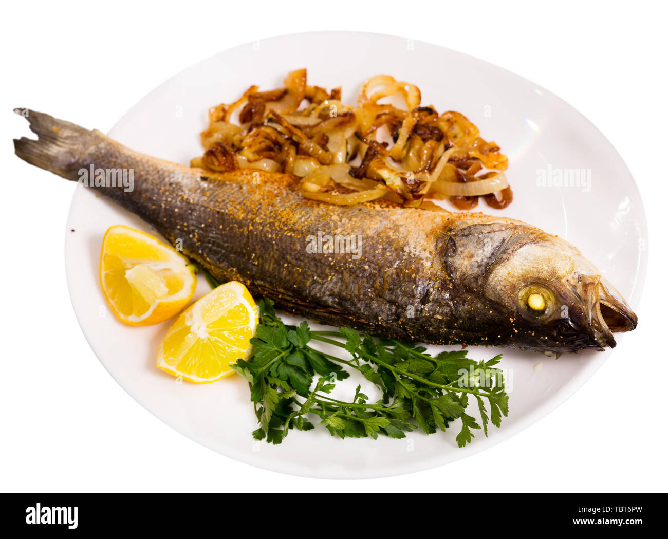 Plate of tasty fish dish – baked sea bass served with fried onion and ...