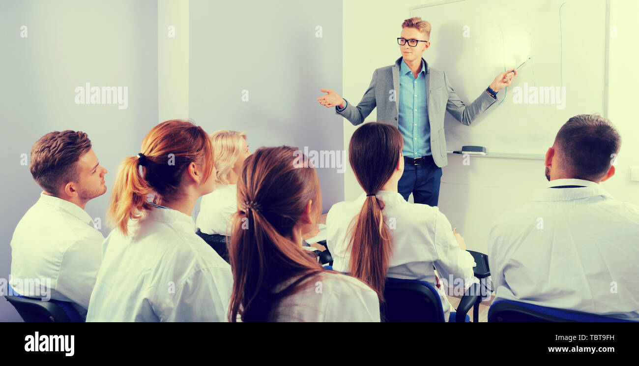 Male teacher lecturing to attentive students at auditorium Stock Photo ...