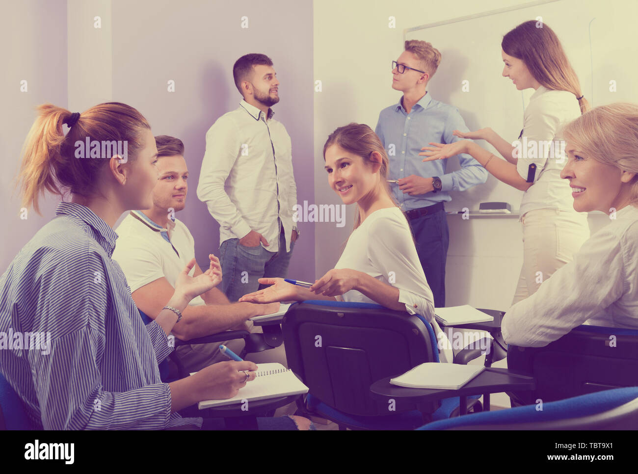 positive young students talking with teacher and with each other on ...