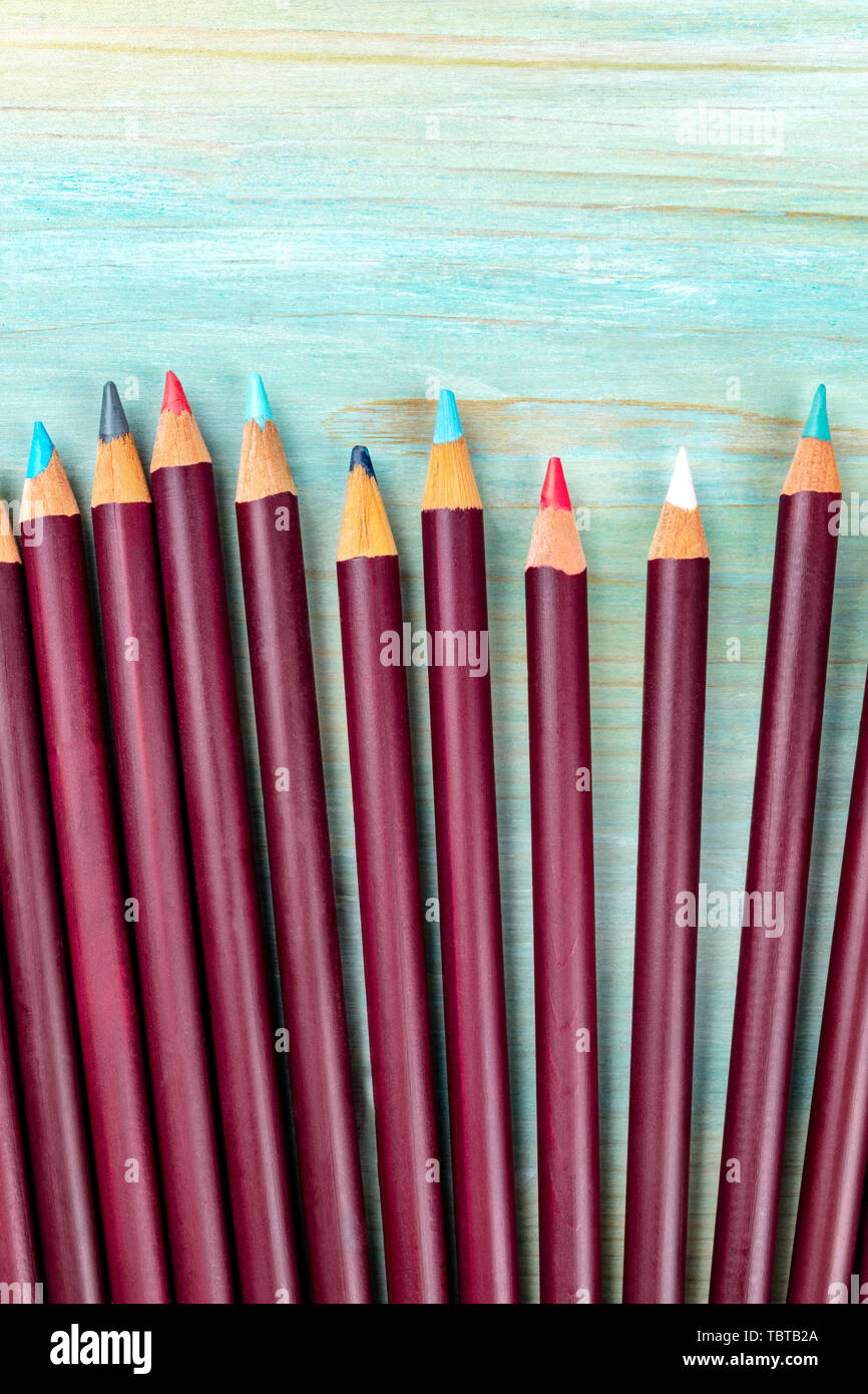Color pencils, shot from the top on a vibrant teal blue background with ...