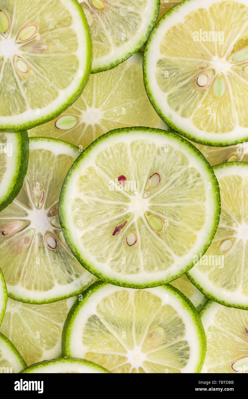 Green lemon slices on white background Stock Photo - Alamy