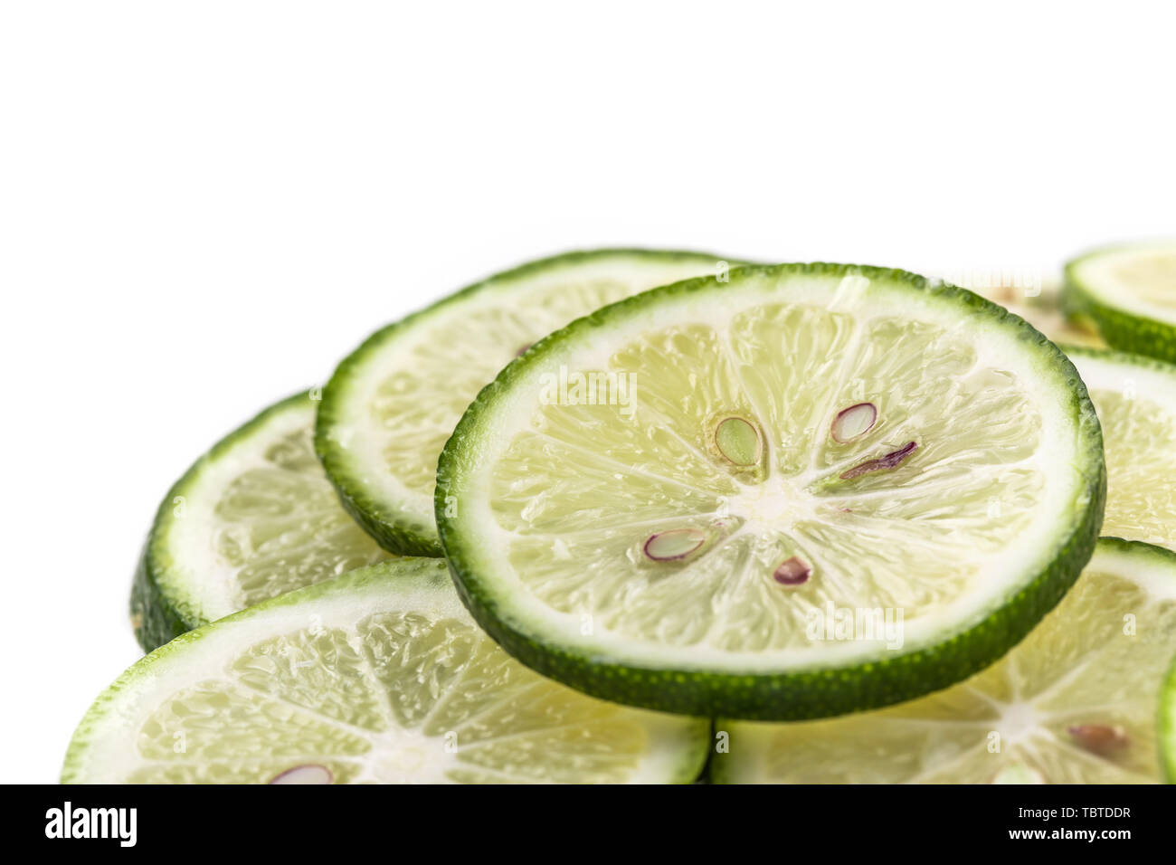 Green lemon slices on white background Stock Photo - Alamy