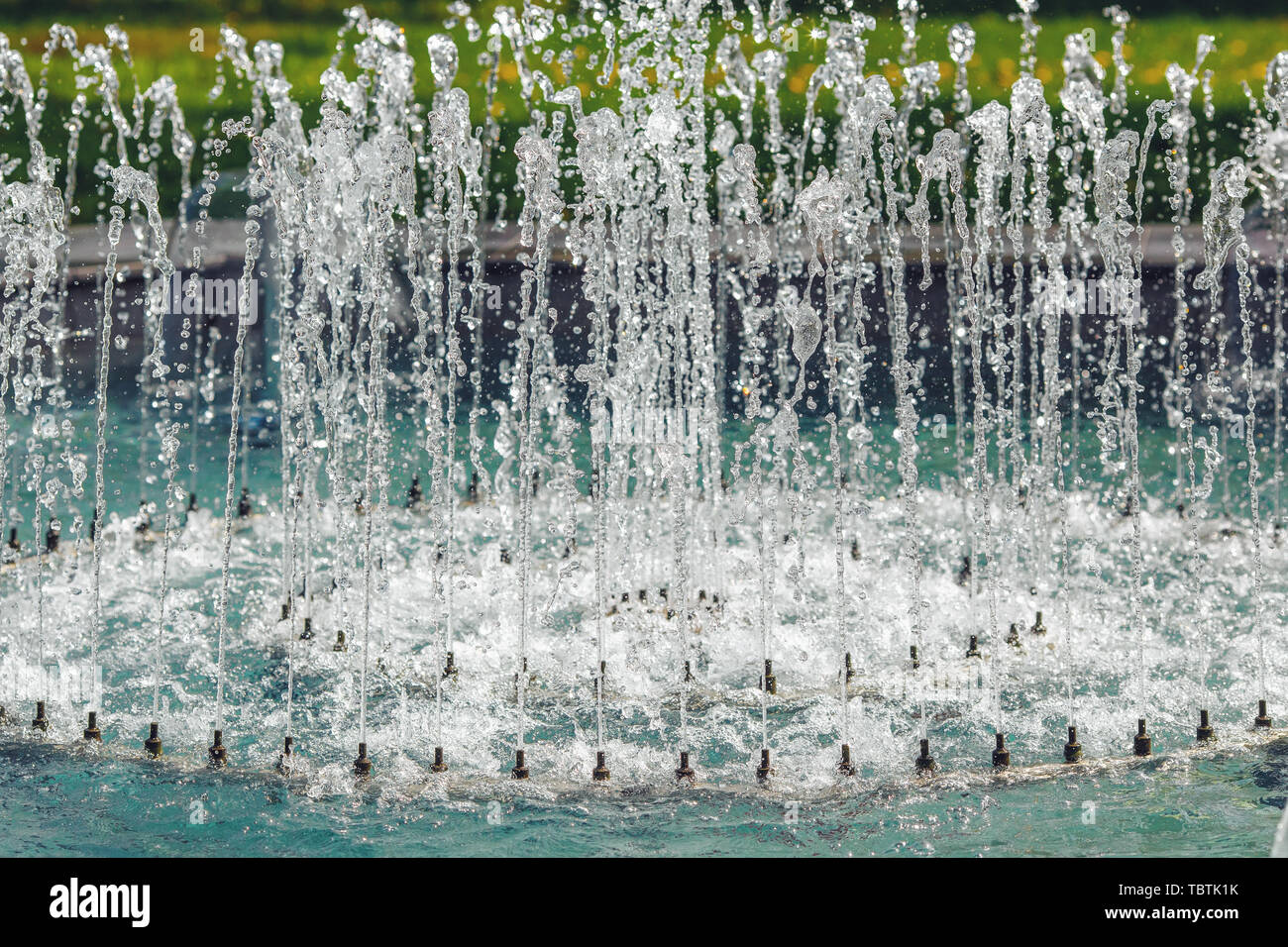 Fountain with copper pipes, foamy blue water and jets Stock Photo - Alamy