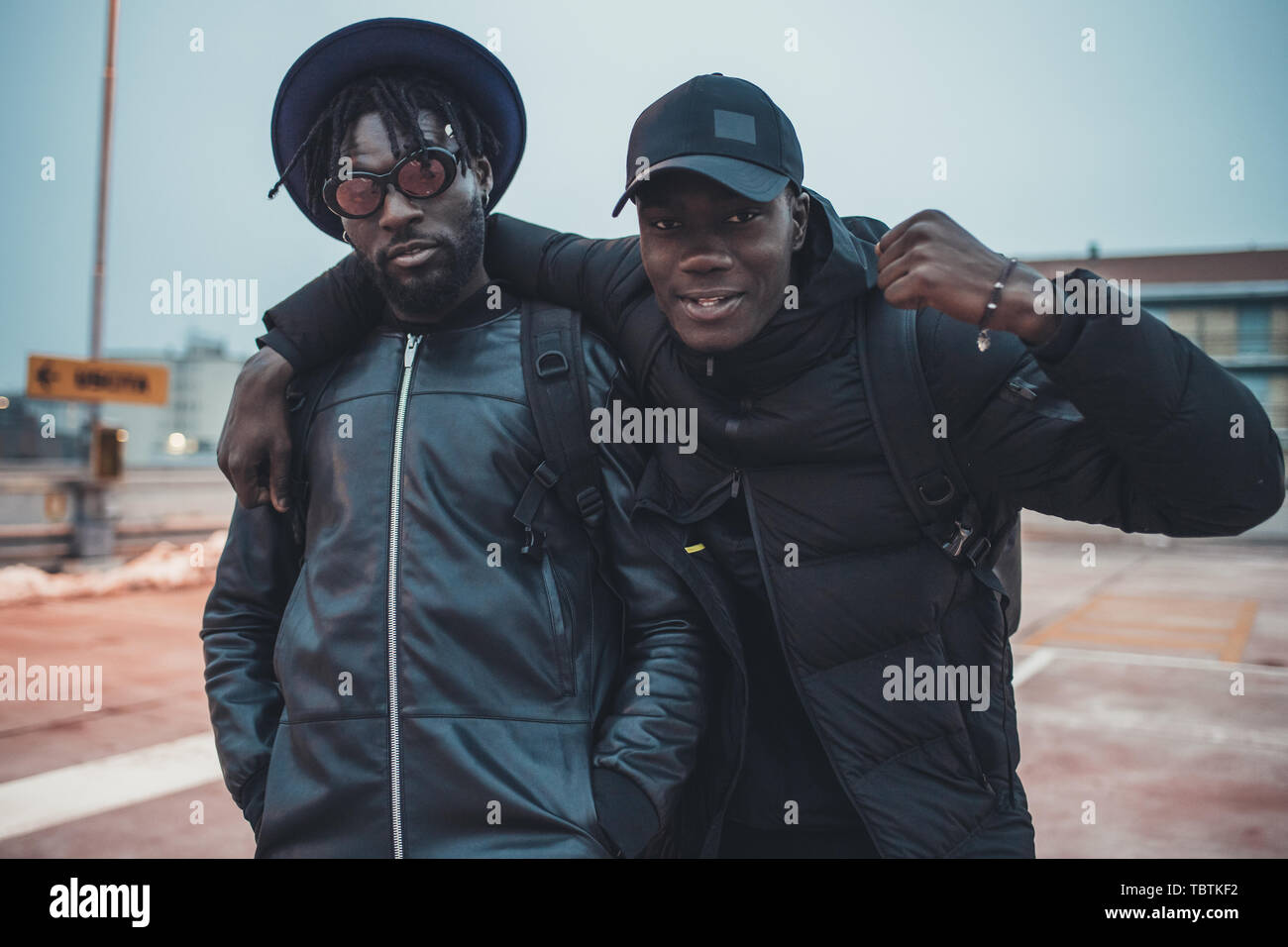 two young african men posing together in the street and looking camera ...