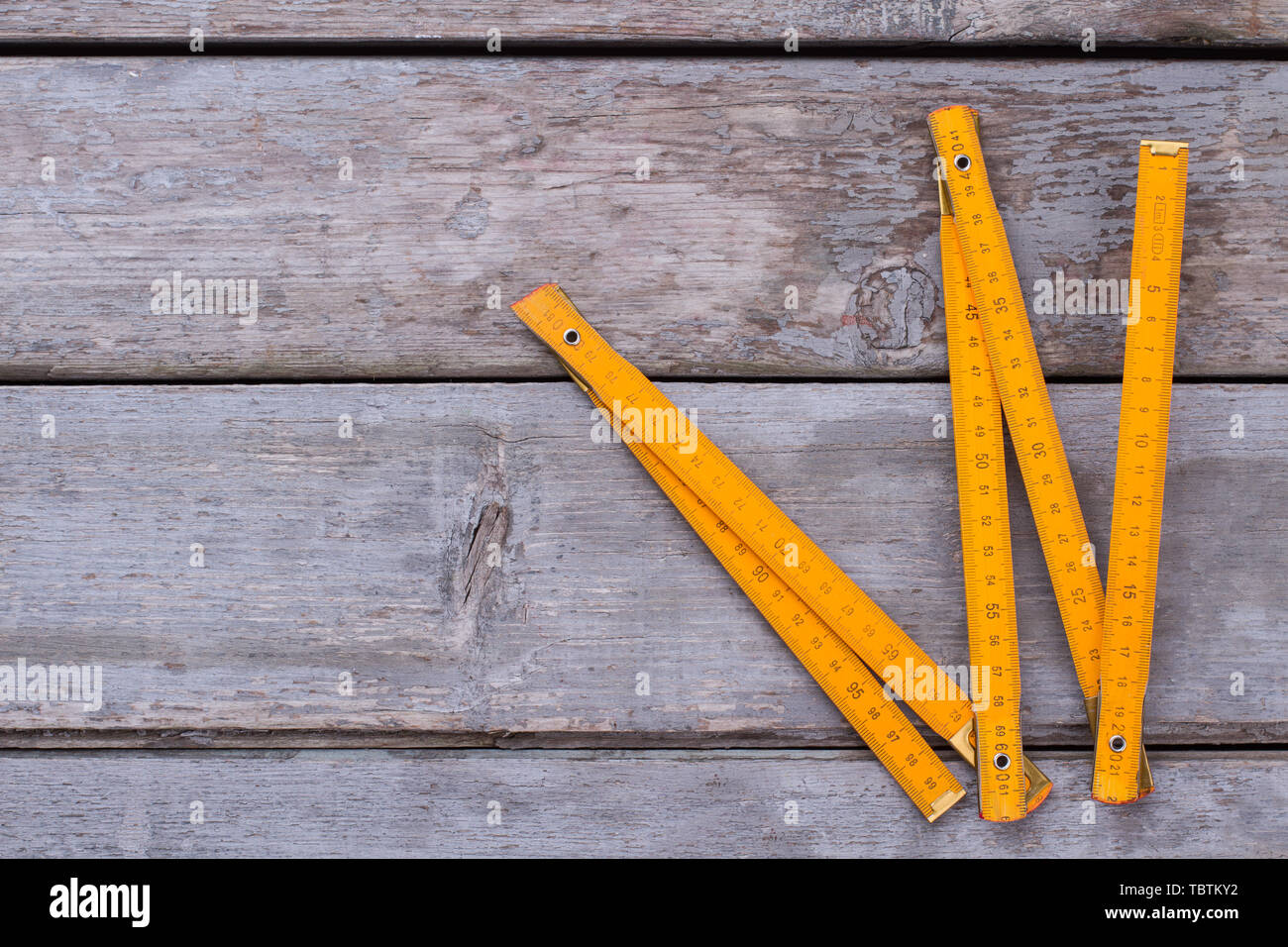 Folding ruler on old wooden background. Yellow folding ruler on rustic ...