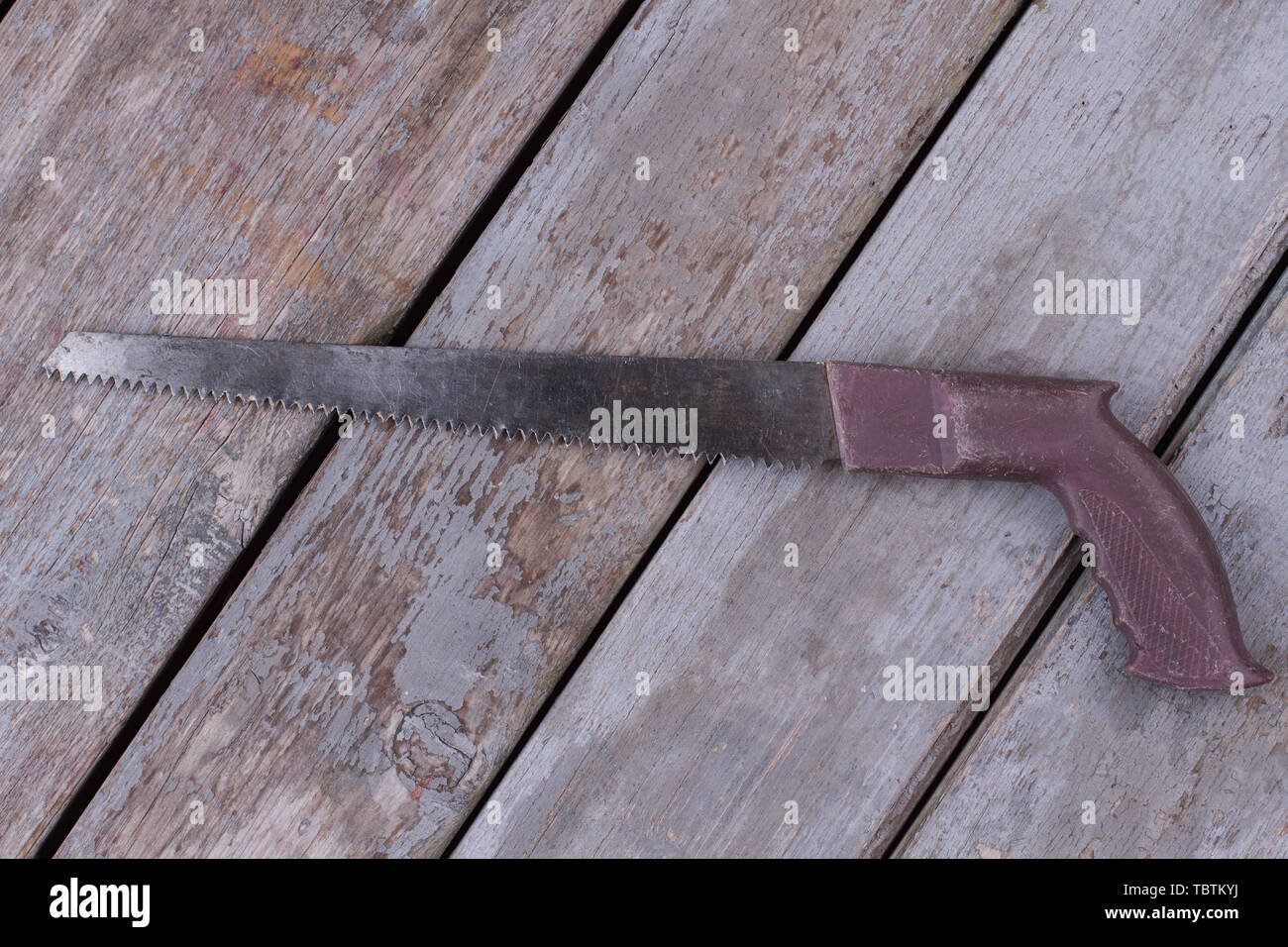 Old rusty hand saw. Carpenters tool on vintage wooden boards background ...