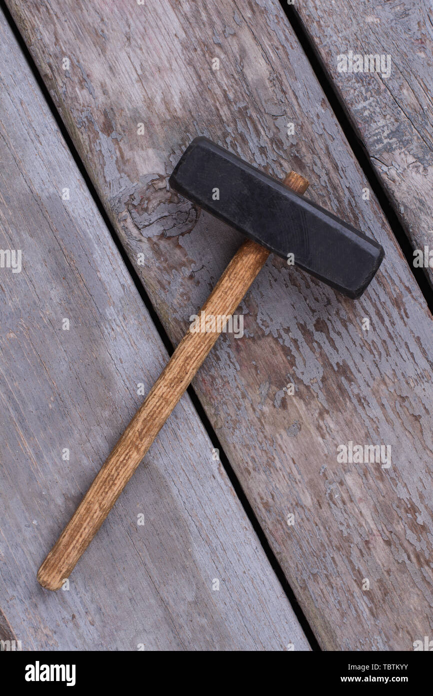 Hammer on the boards, top view. Old steel hammer with wooden handle on ...