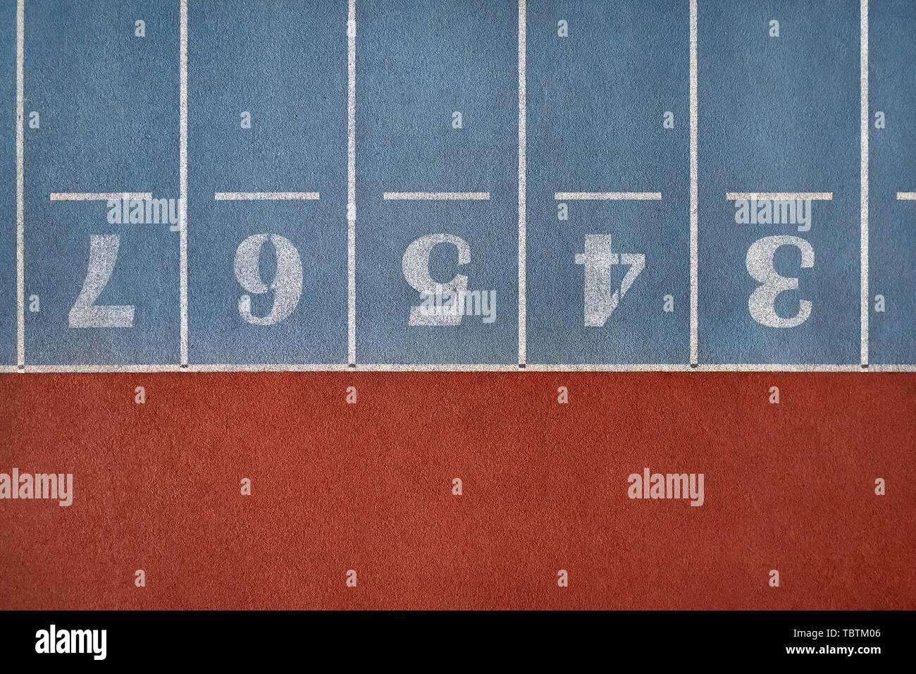 Blue running tracks with white lines and start numbers on the red ...