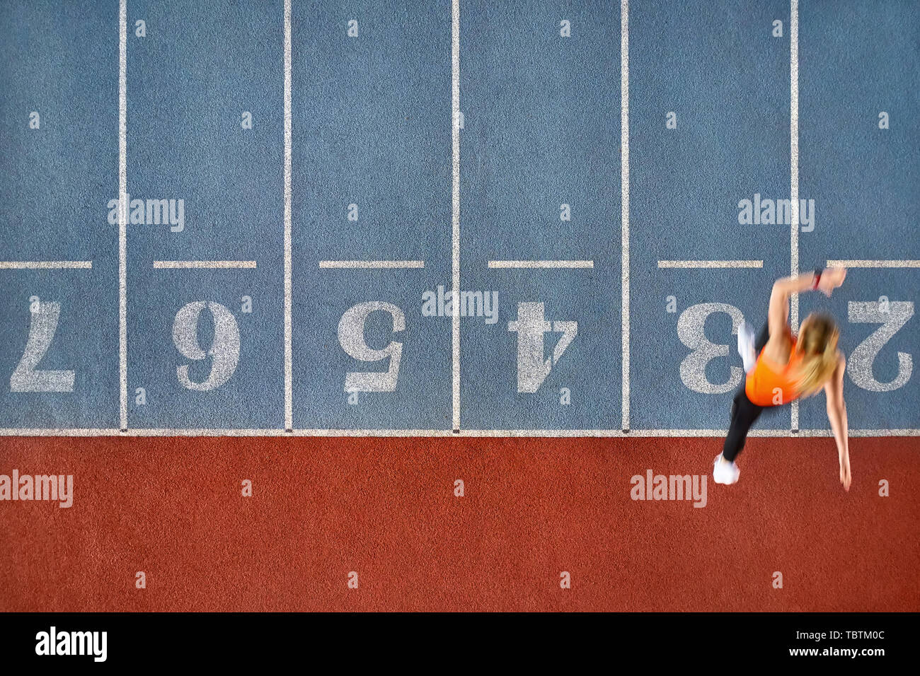 Gorgeous girl in an orange T-shirt with black pants and gray sneakers ...