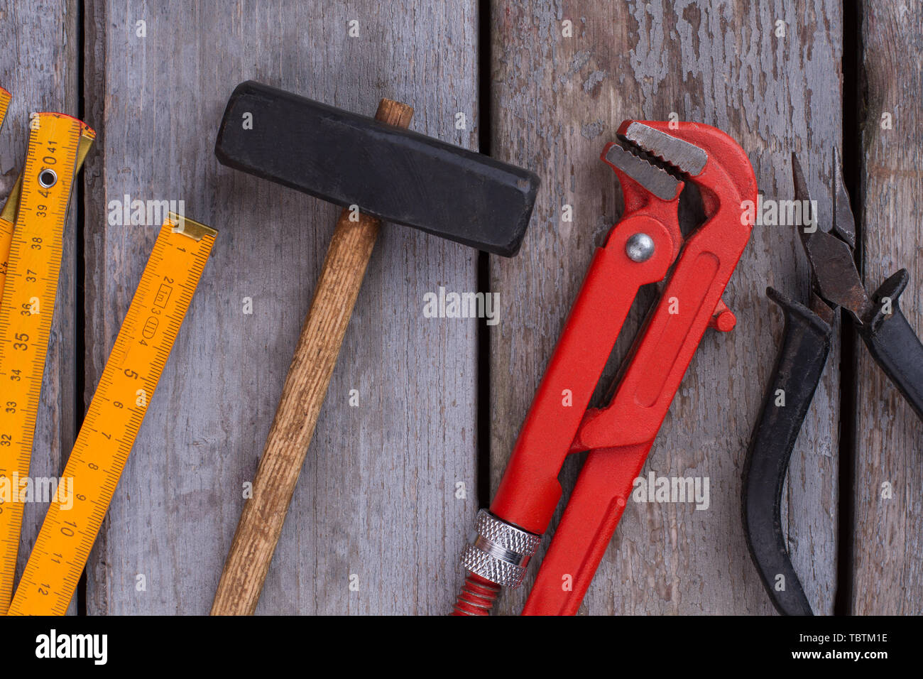 Hammer, ruler and pliers on wooden background. Different kinds of tools ...