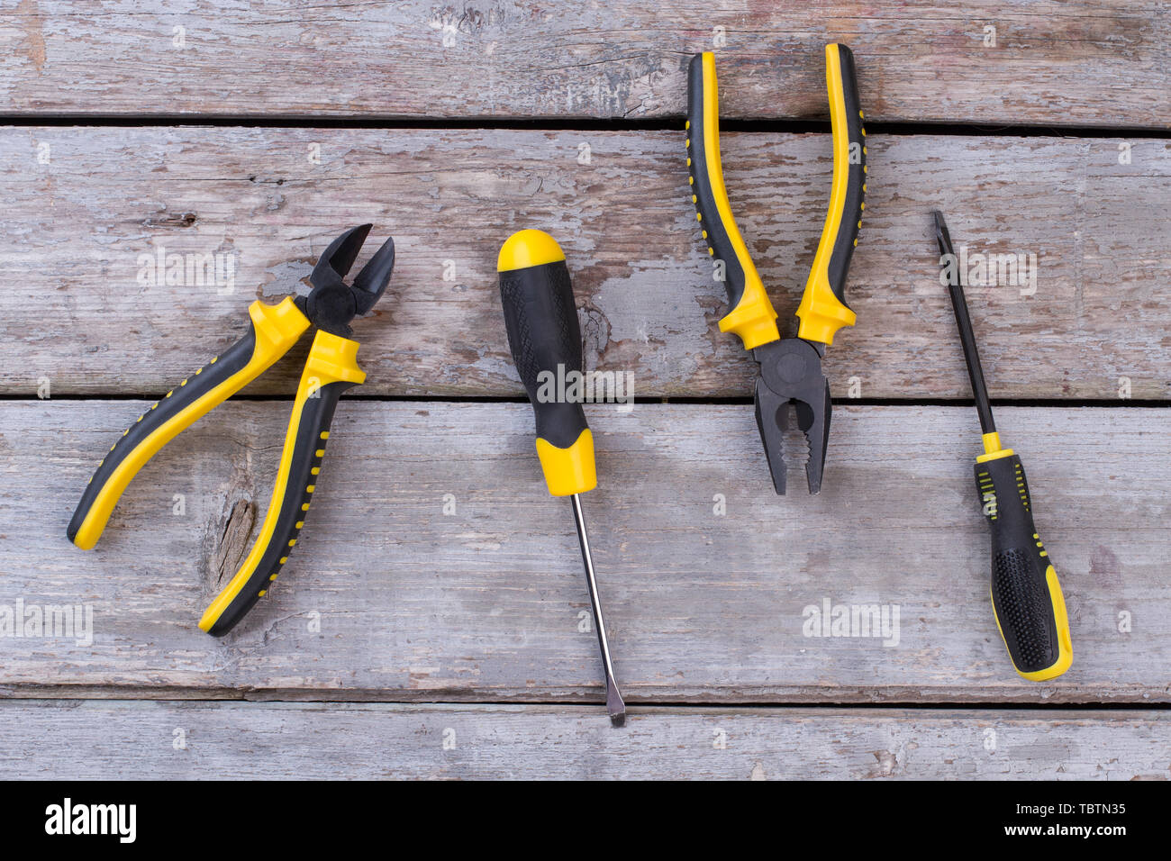Pliers and screwdrivers on wooden background. Construction tools with ...