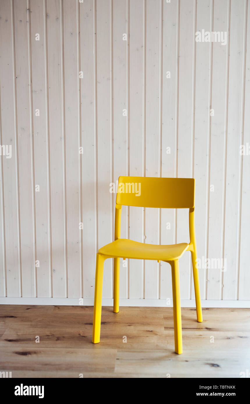 A plastic yellow chair against white wood texture background Stock ...