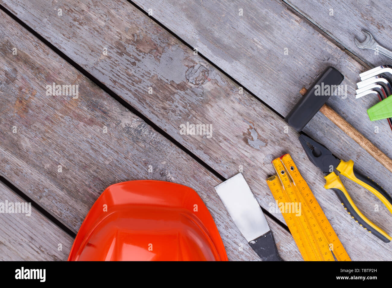 Construction tools on wooden background. Hardhat, spatula, folding ...