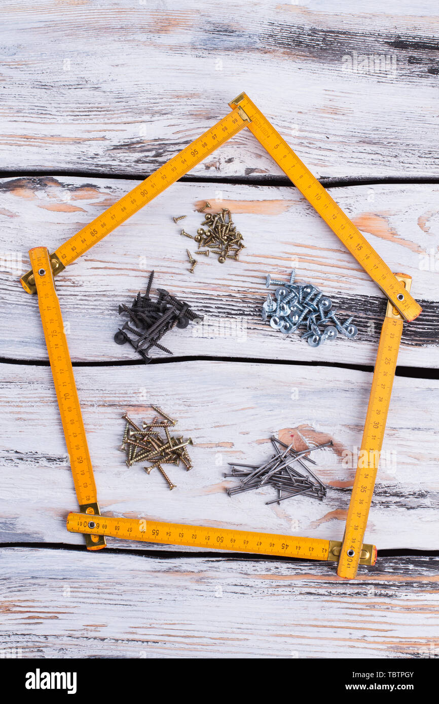 Folding ruler in a shape of house on wooden background. Composition ...