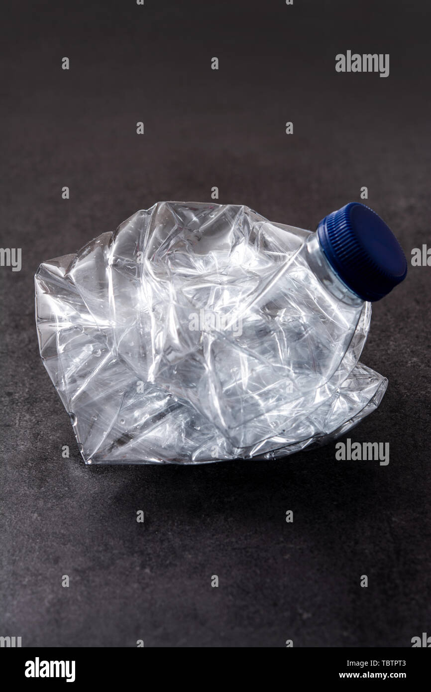 Disposable waste plastic bottle on black background Stock Photo - Alamy