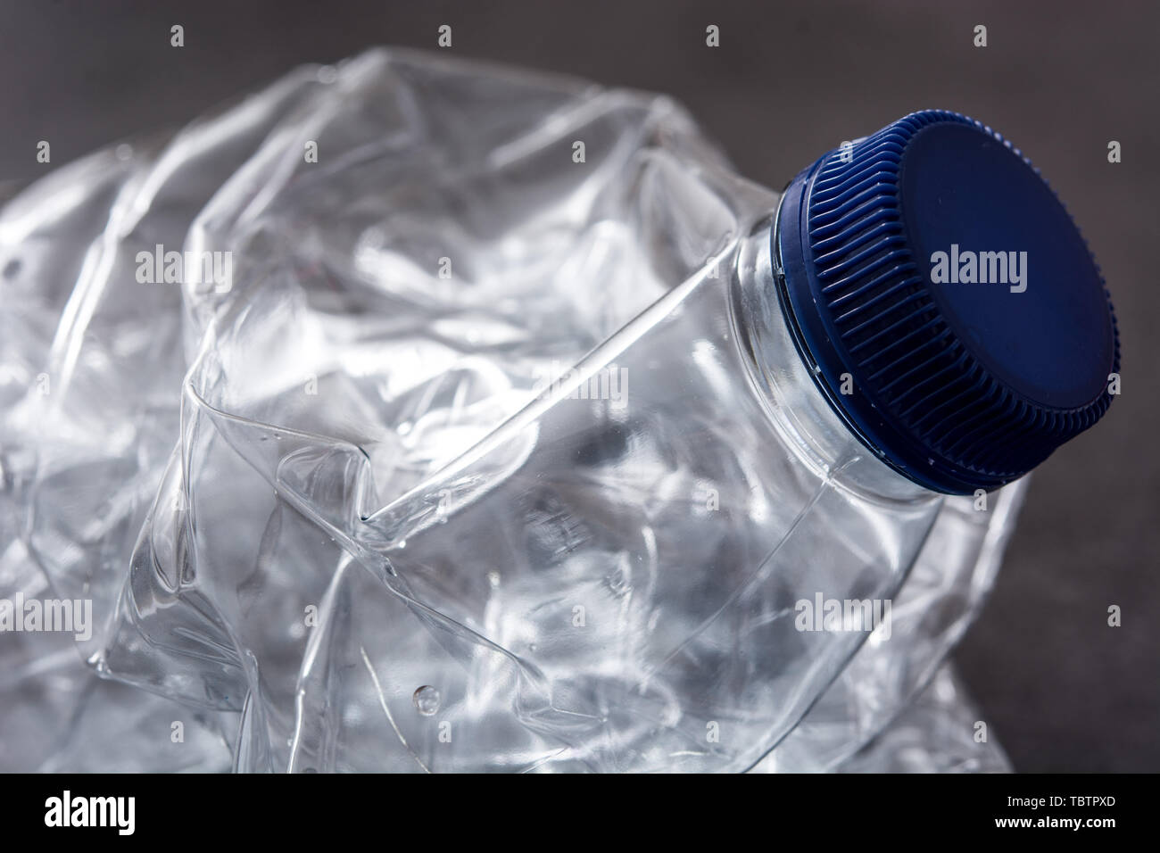 Disposable waste plastic bottle on black background Stock Photo - Alamy