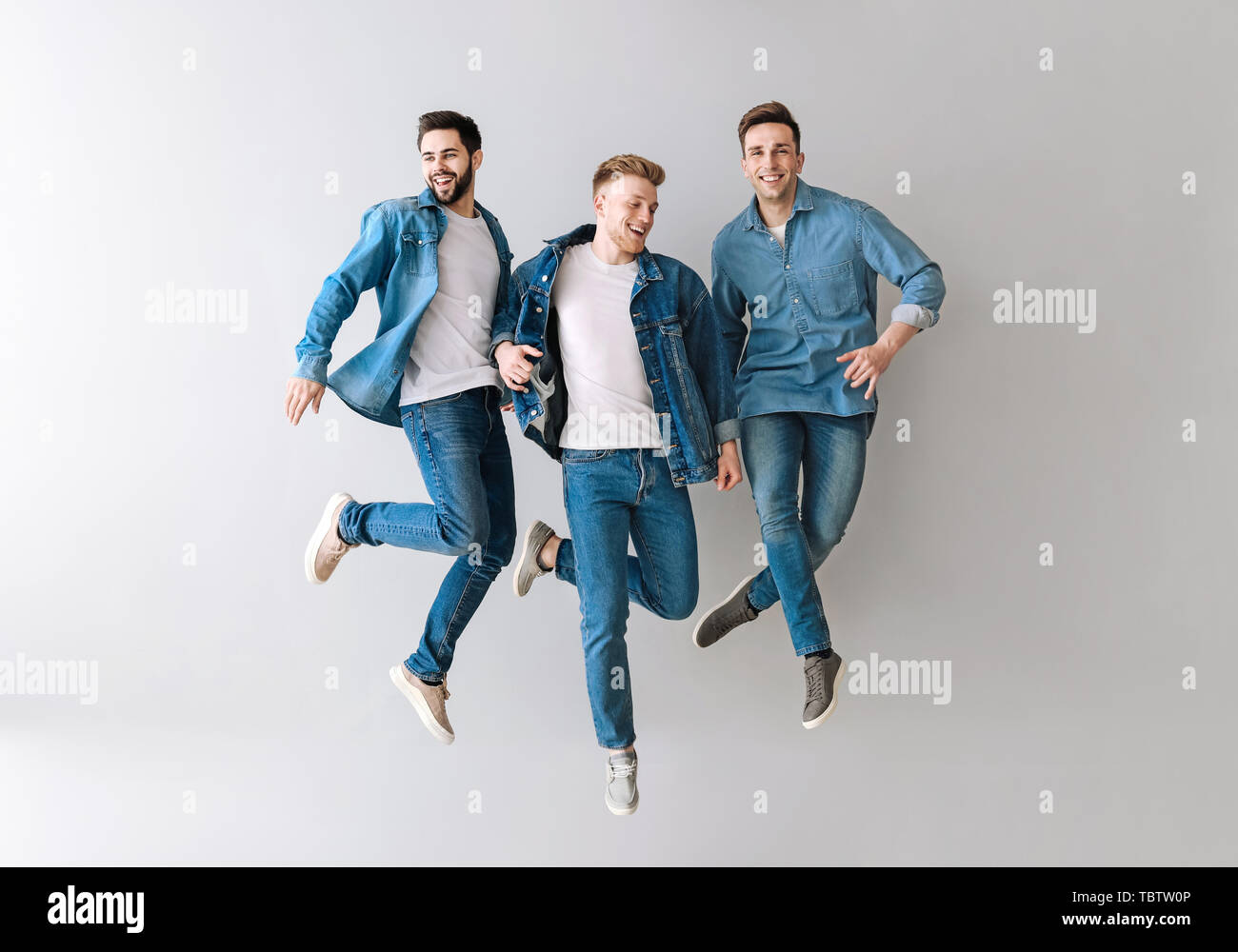 Jumping young men on light background Stock Photo - Alamy