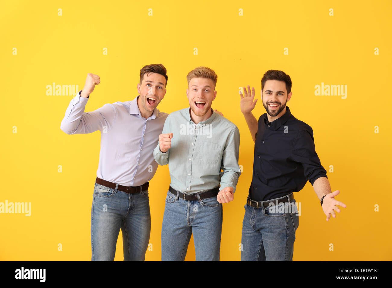 Happy young men on color background Stock Photo - Alamy