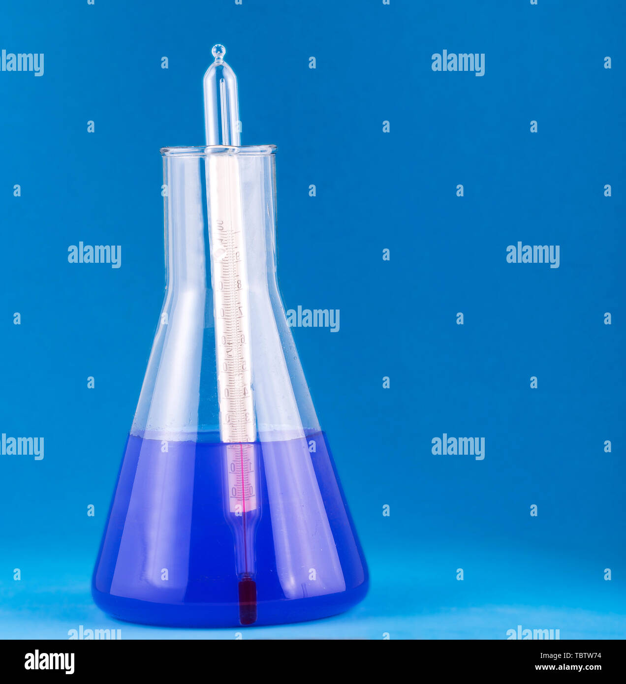 Laboratory Flask With Thermometer On Blue Background With Copy Space
