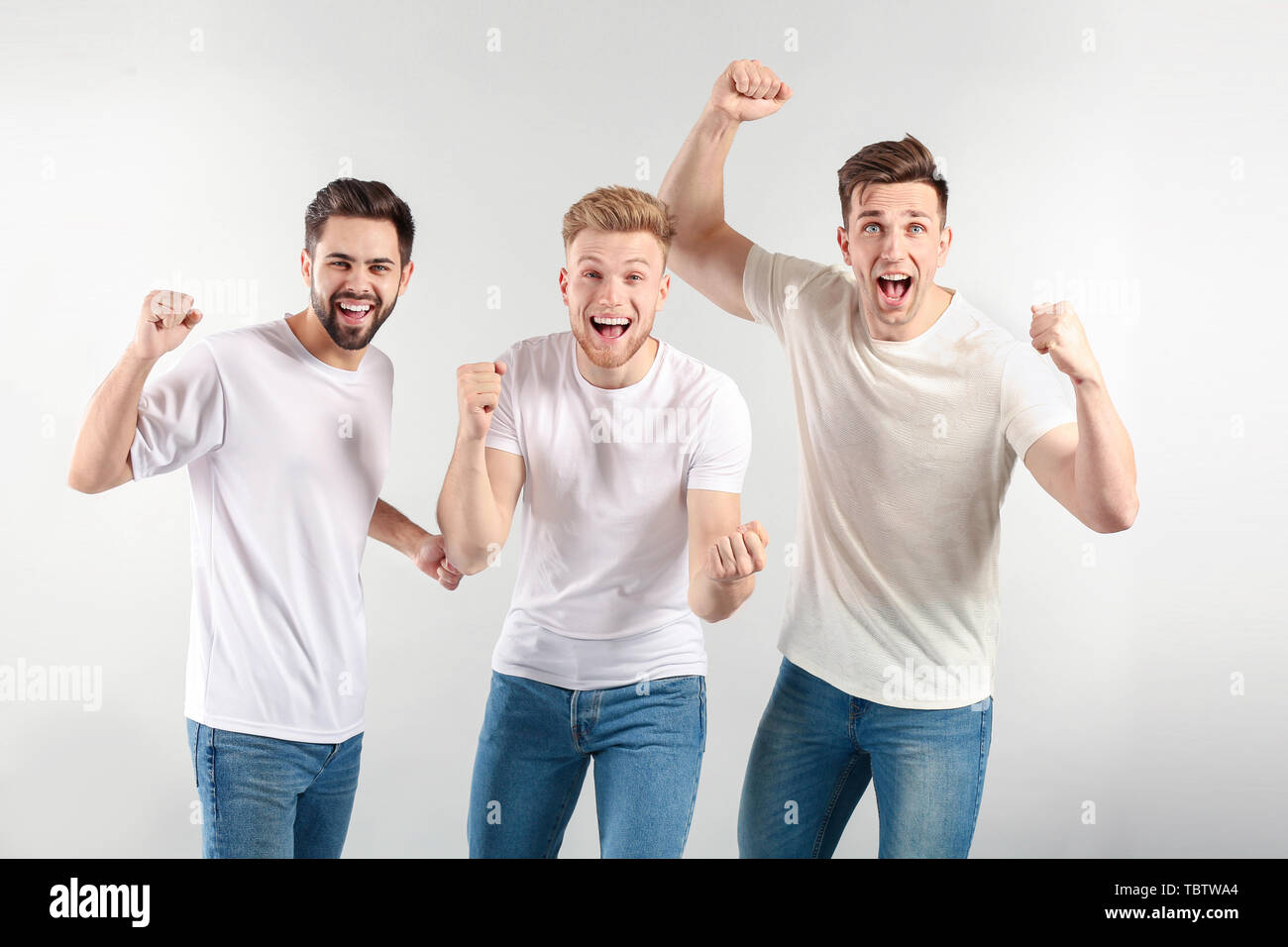 Happy young men on light background Stock Photo - Alamy