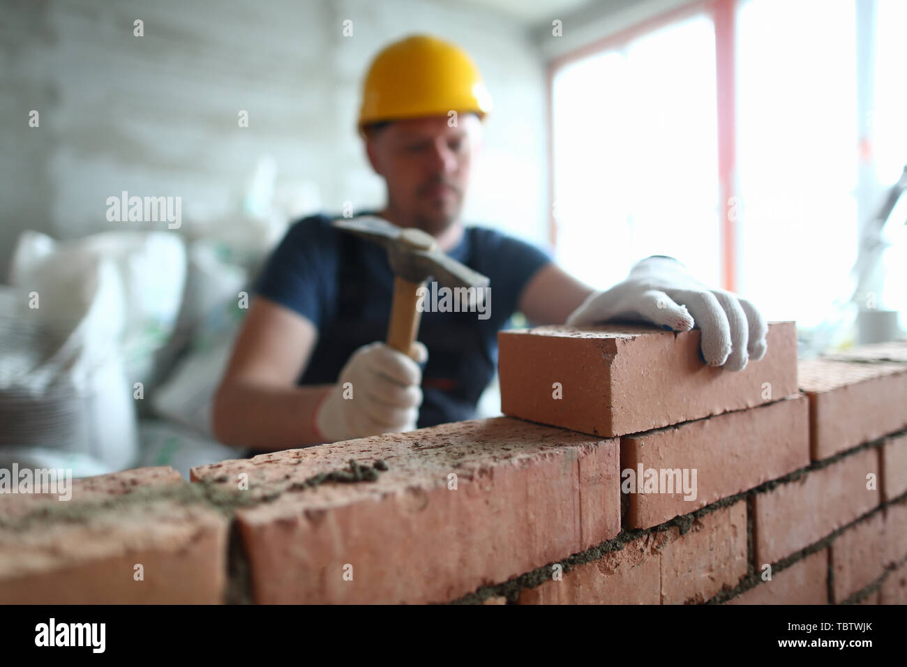 Portrait of skilled man constructing big concrete wall and using ...