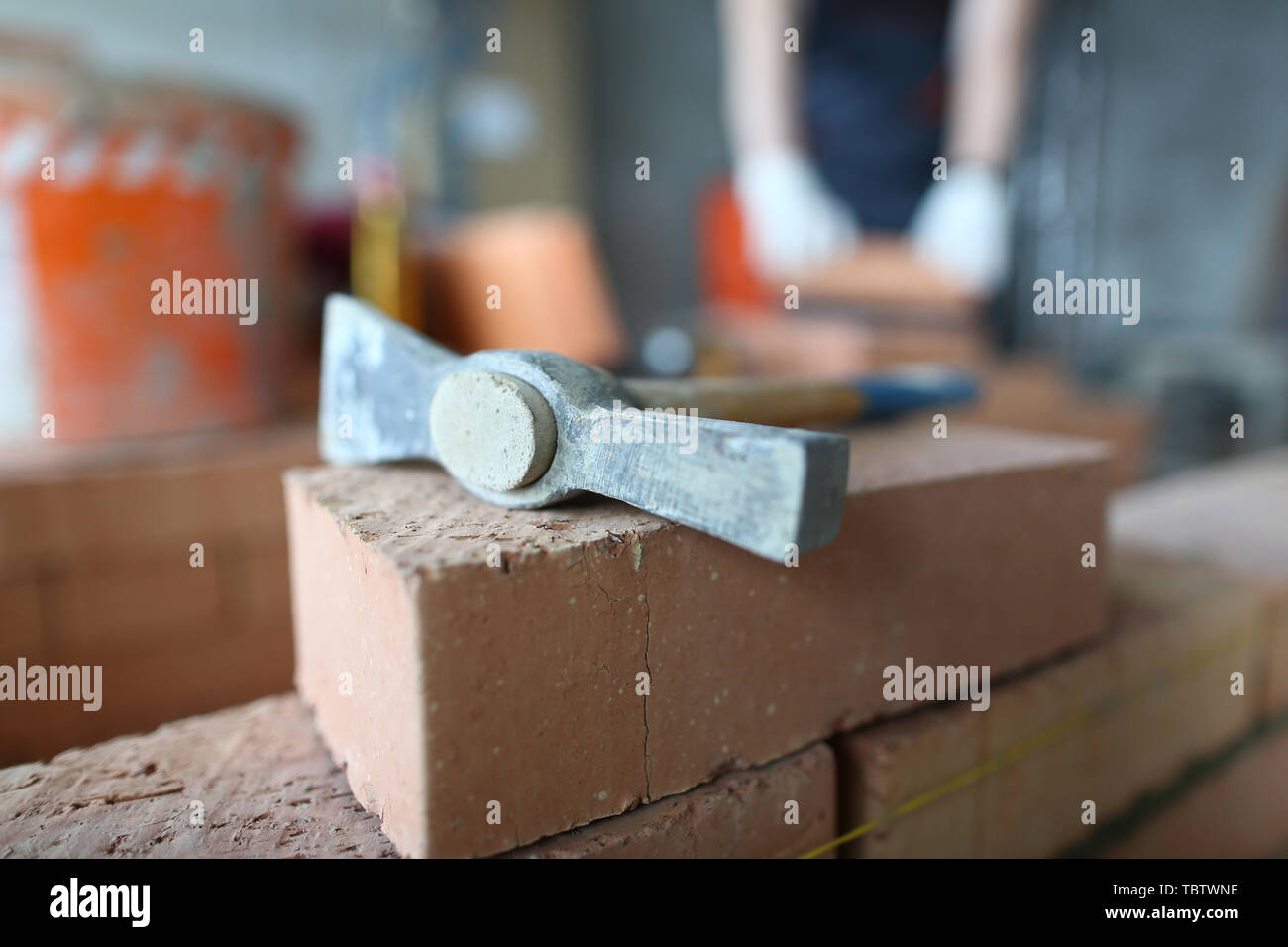 Focus on structure utensil lying on big red bricks. Smart man using ...