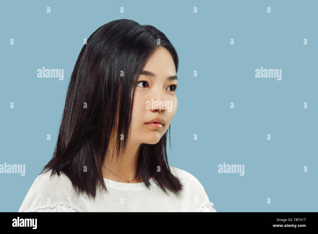 Korean young woman's half-length portrait on blue studio background ...