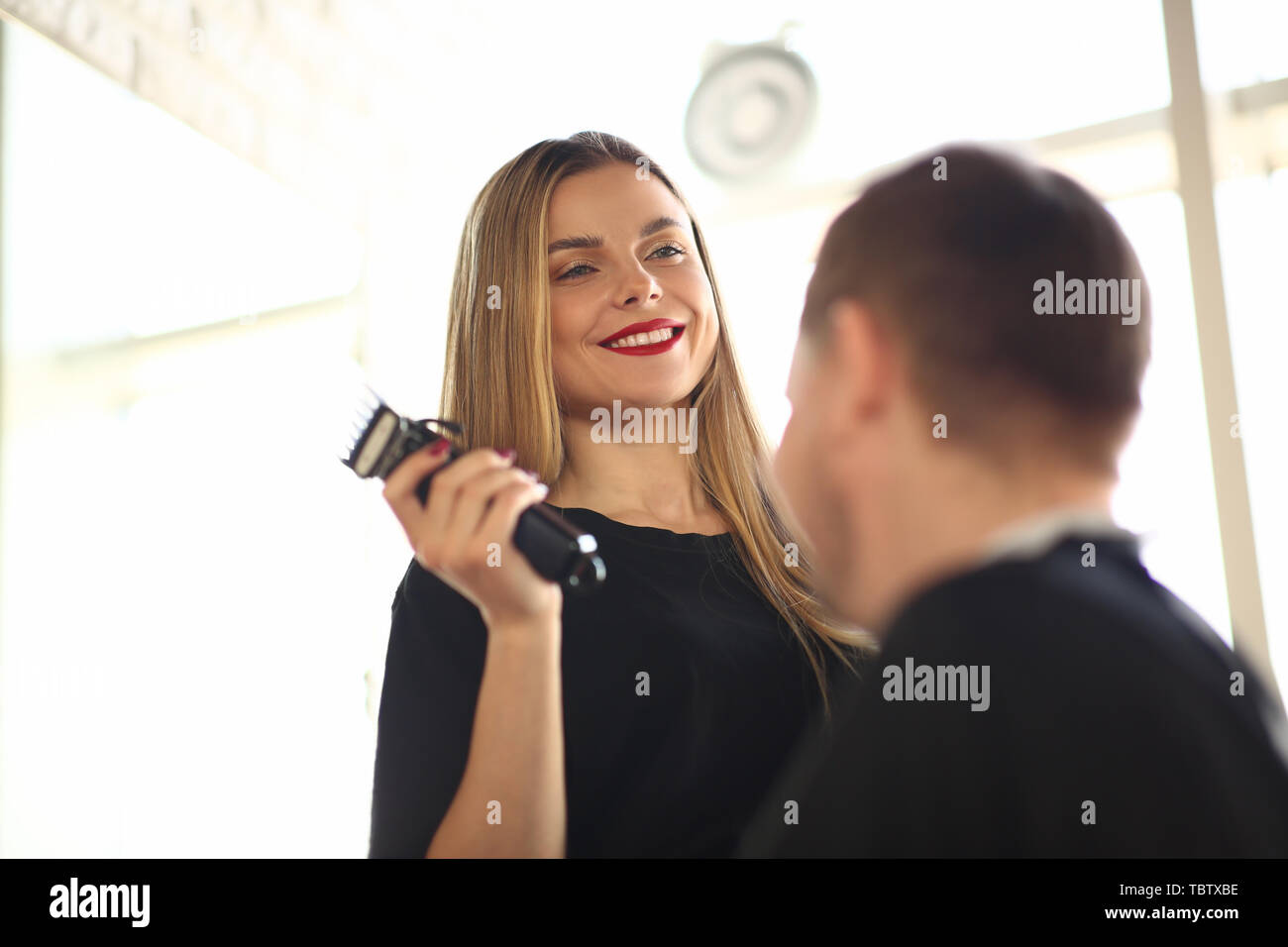 Smiling Hairdresser Using Electric Razor to Client. Professional ...
